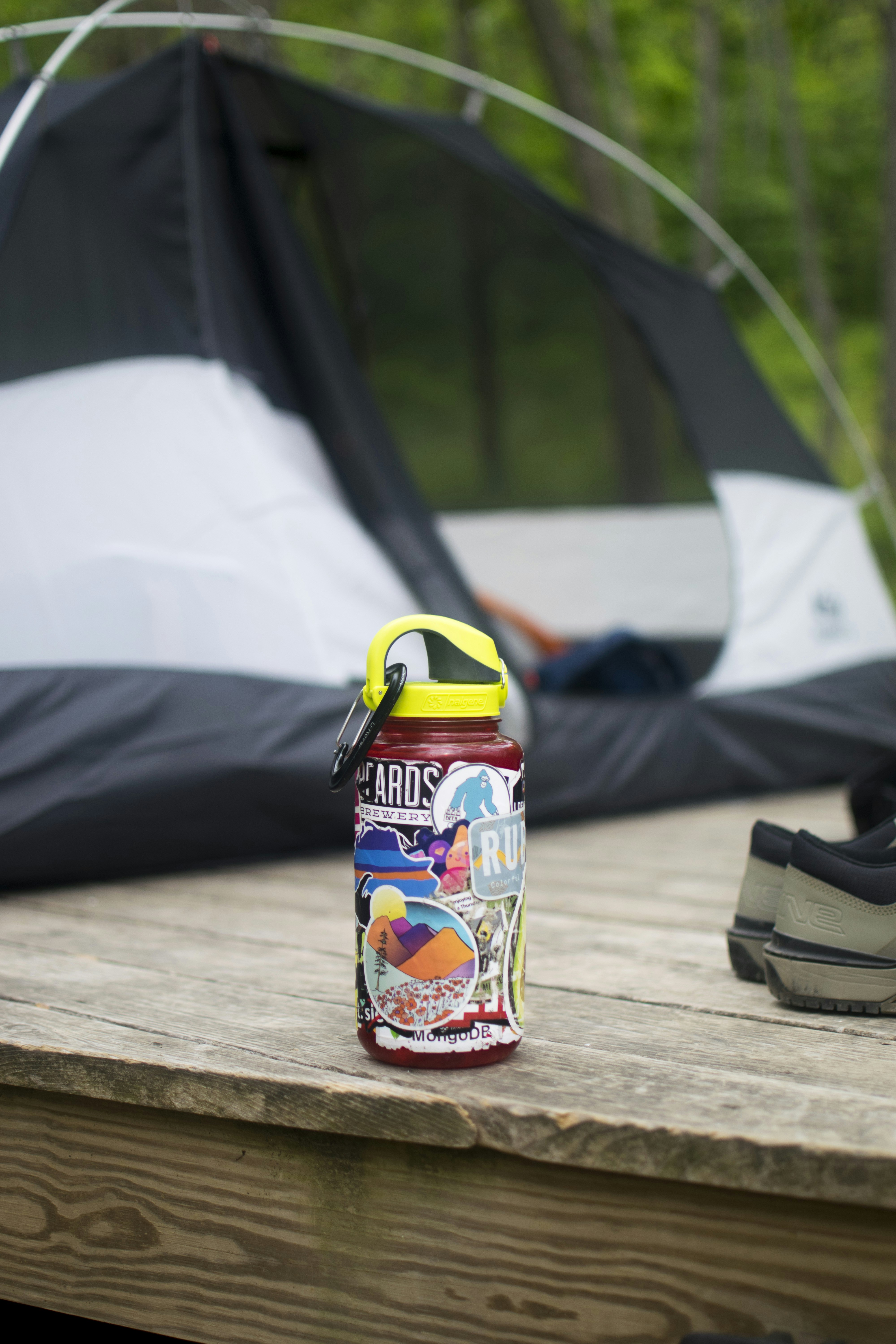 Stickered Hydration Bottle on a Weathered Deck Anchors a Tranquil Camp Scene
