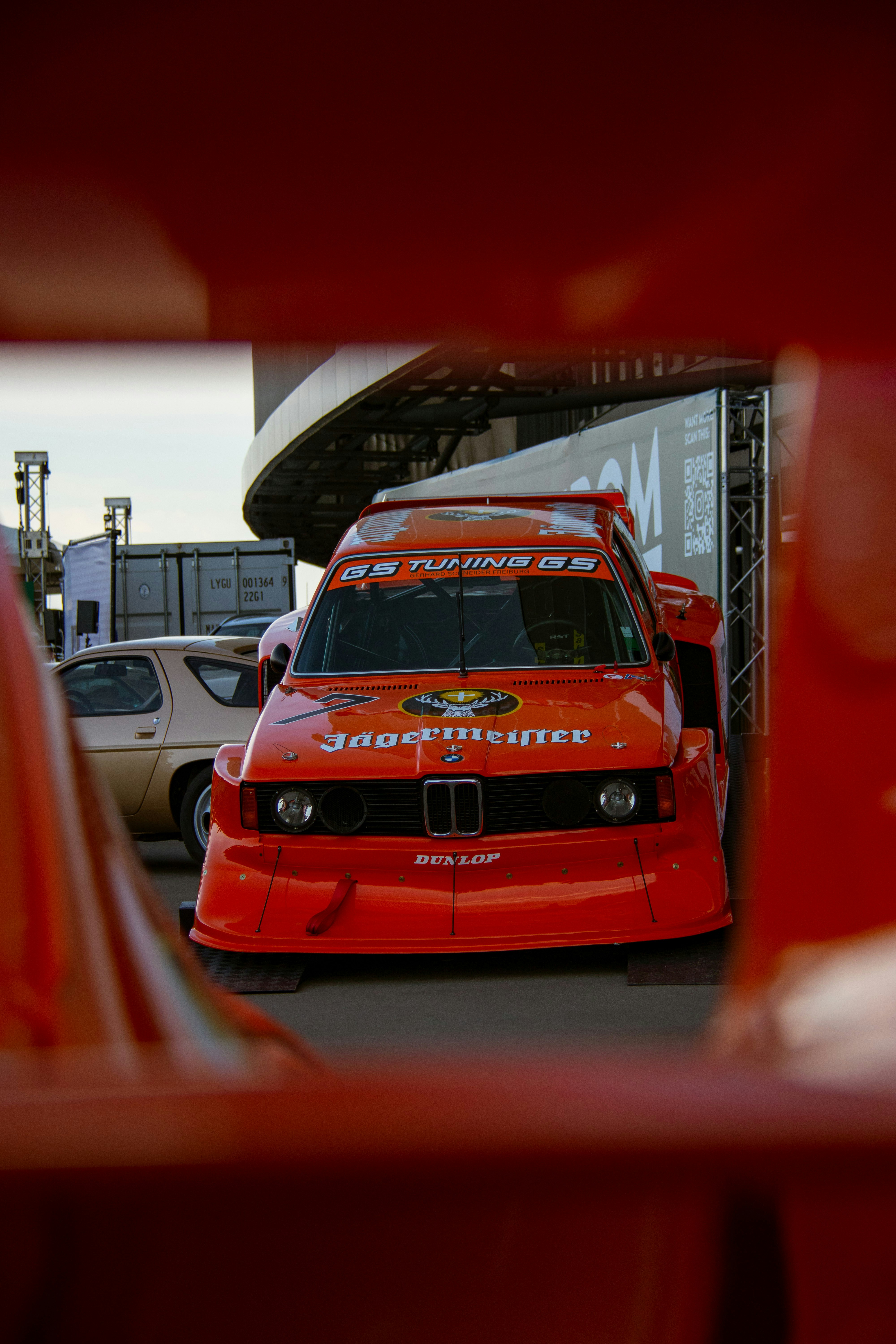 Crimson Aperture: Jägermeister Race Car Framed by Red Structure