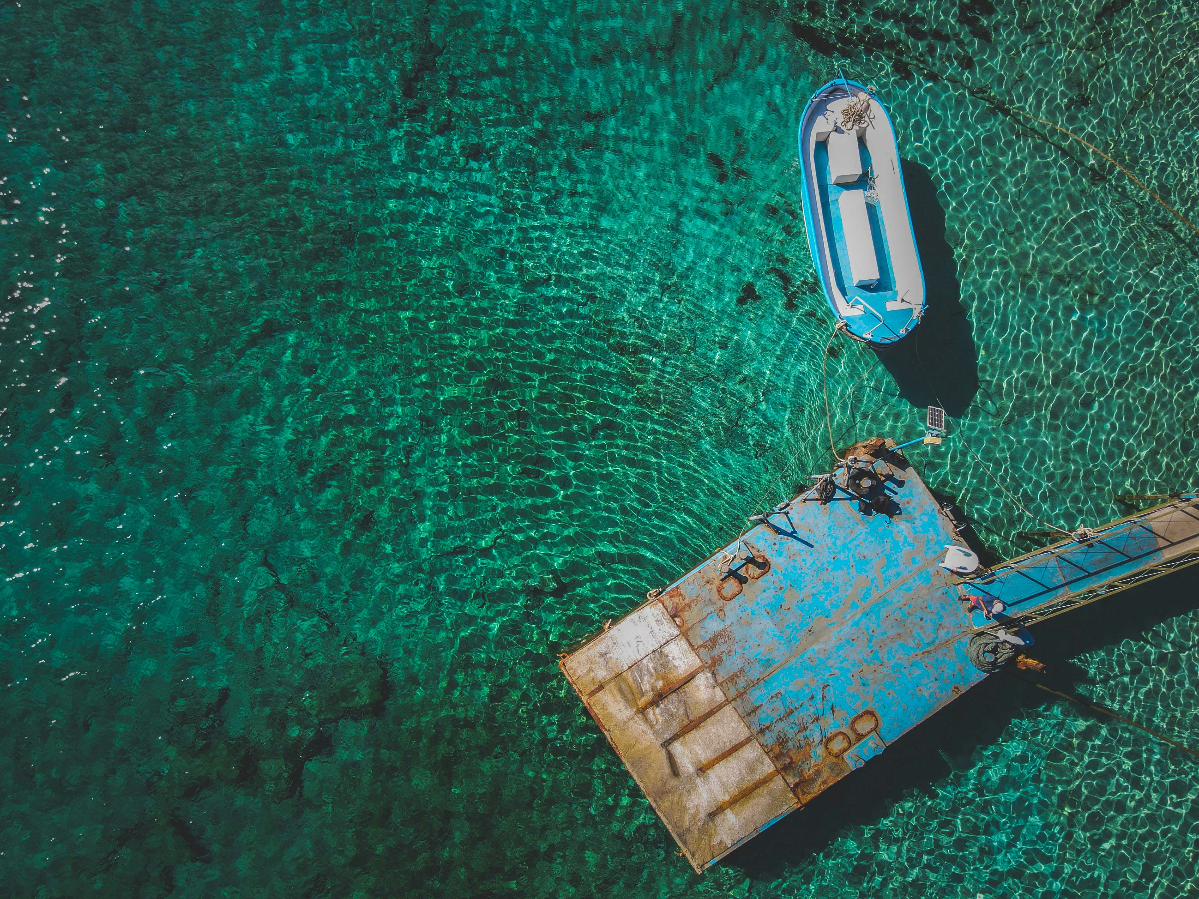 Two boats floating on top of a body of water photo – Free Yacht Image ...