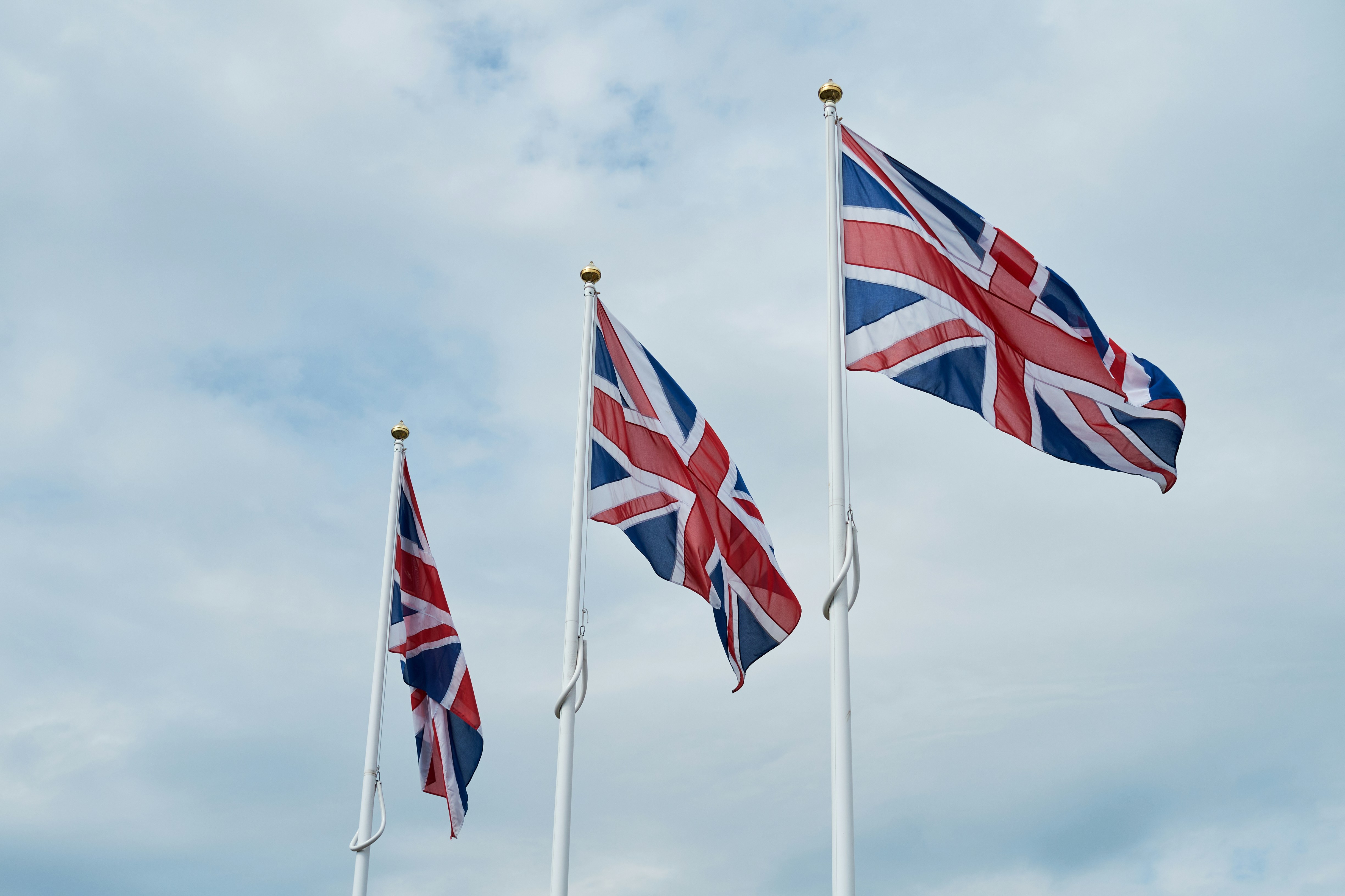 A group of three flags flying in the air photo – Free Flag Image on ...