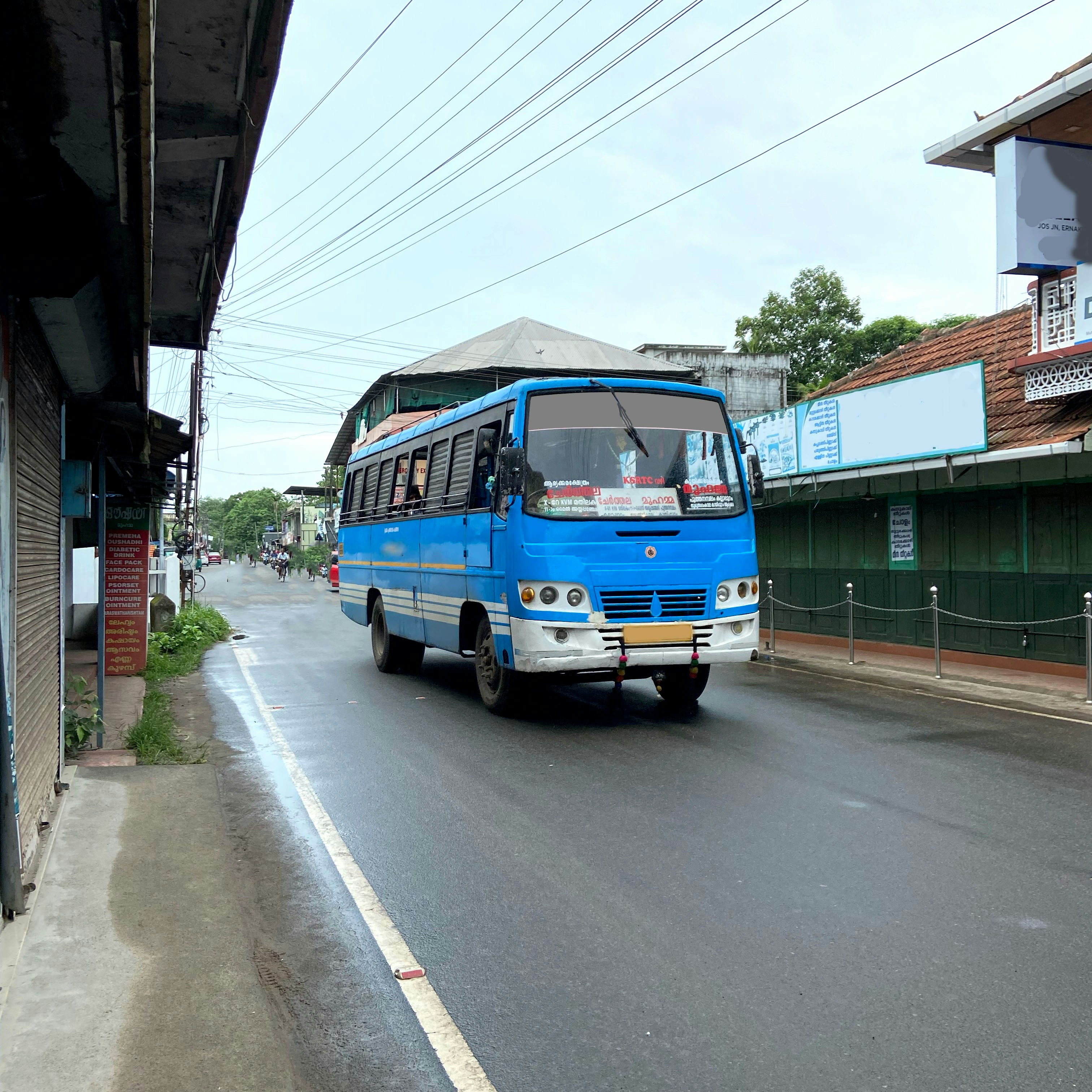 A blue and white bus driving down a street photo – Free Bus Image on ...