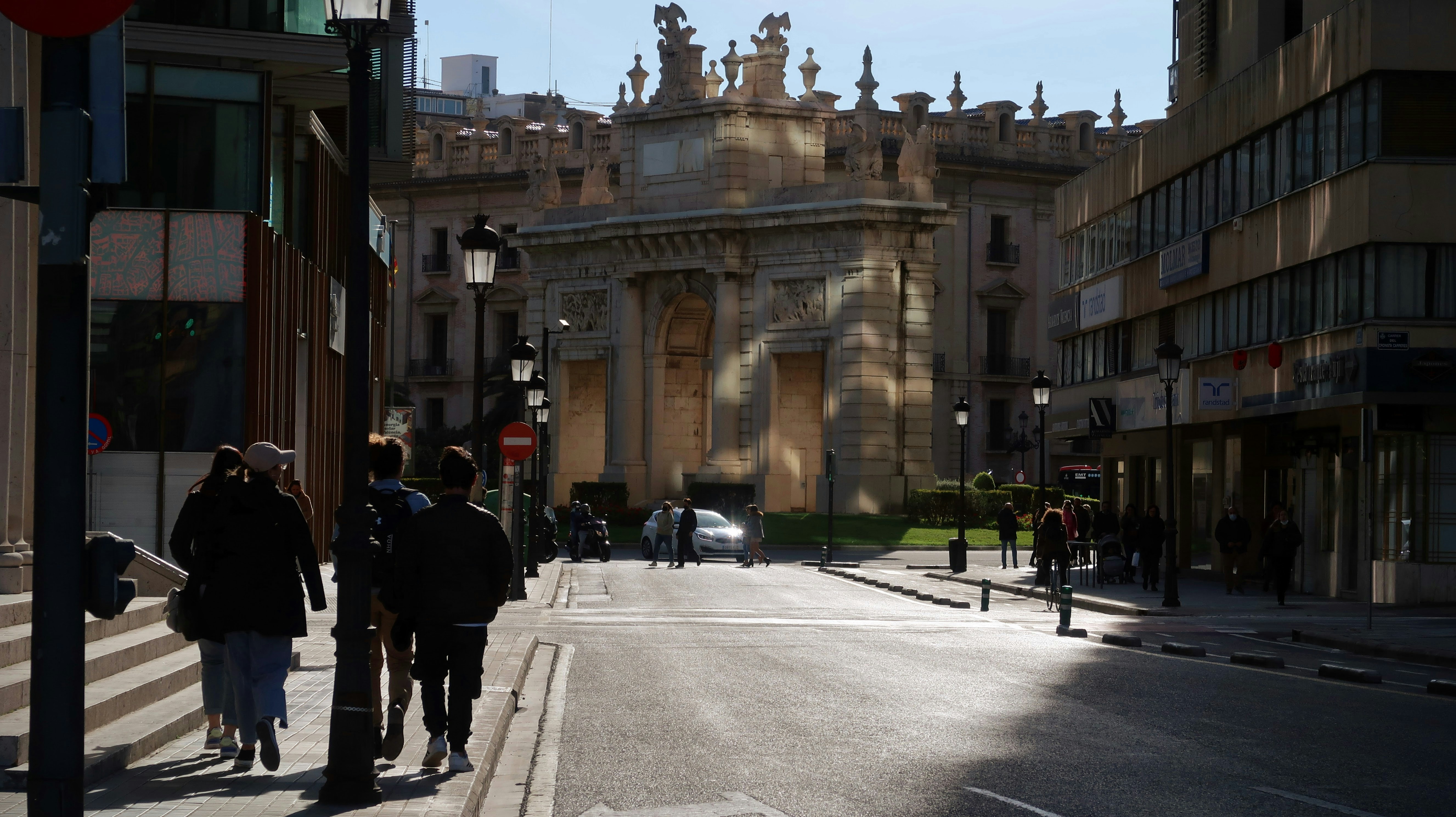 Sunlit Arcway: Pedestrians Head Toward a Grand Historic Gateway