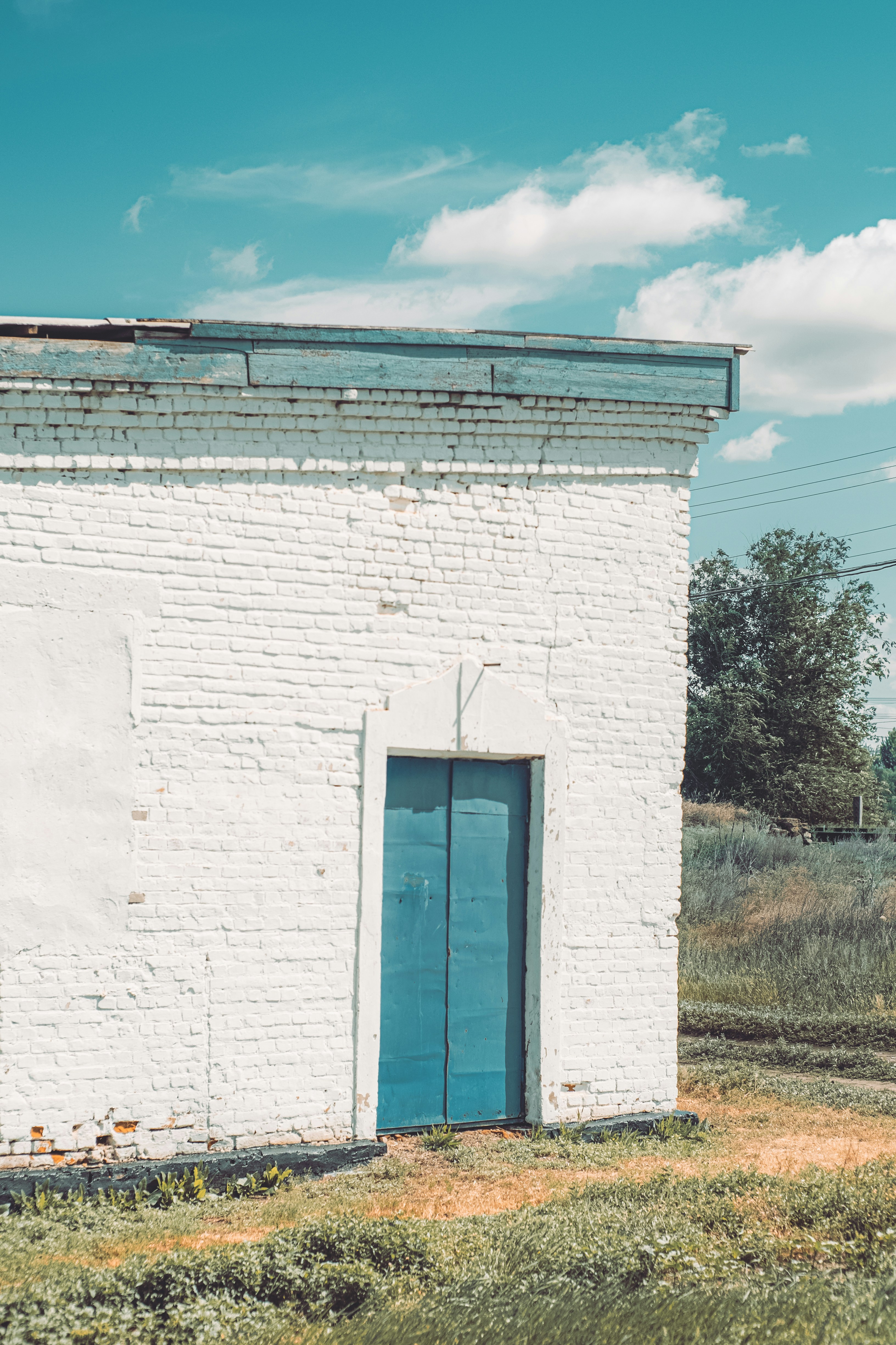 A white brick building with a blue door photo – Free Teal Image on Unsplash