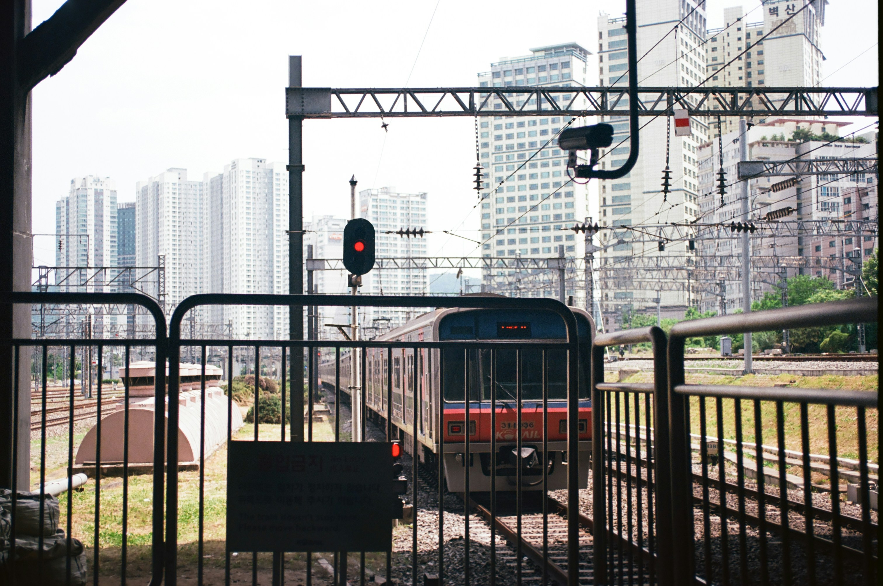 A train traveling through a train station next to tall buildings photo ...