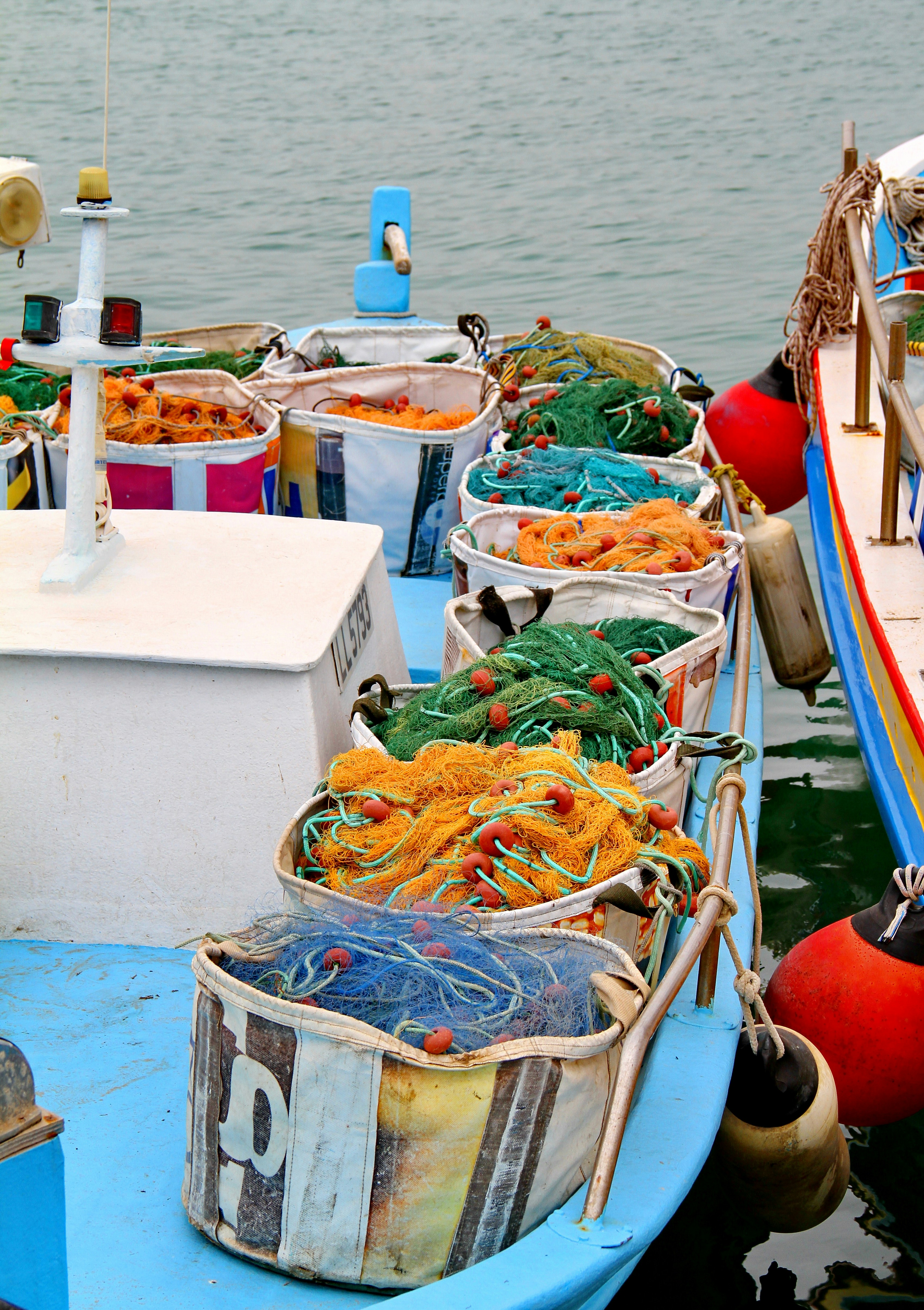 Harbor Palette: Orange Nets Nest Among the Small Fishing Fleet