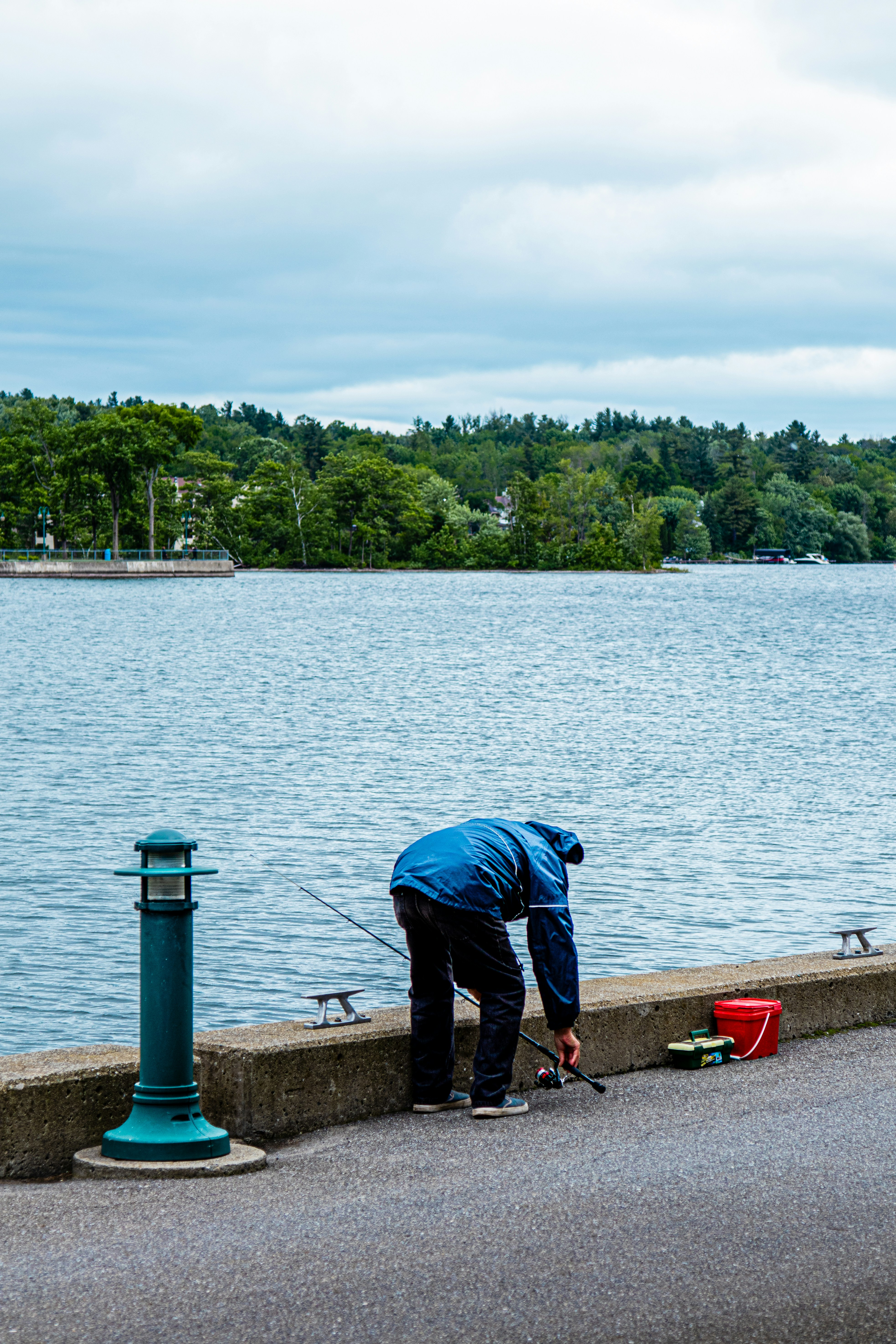 Blue-clad Angler at a Tranquil Lakeside Pier