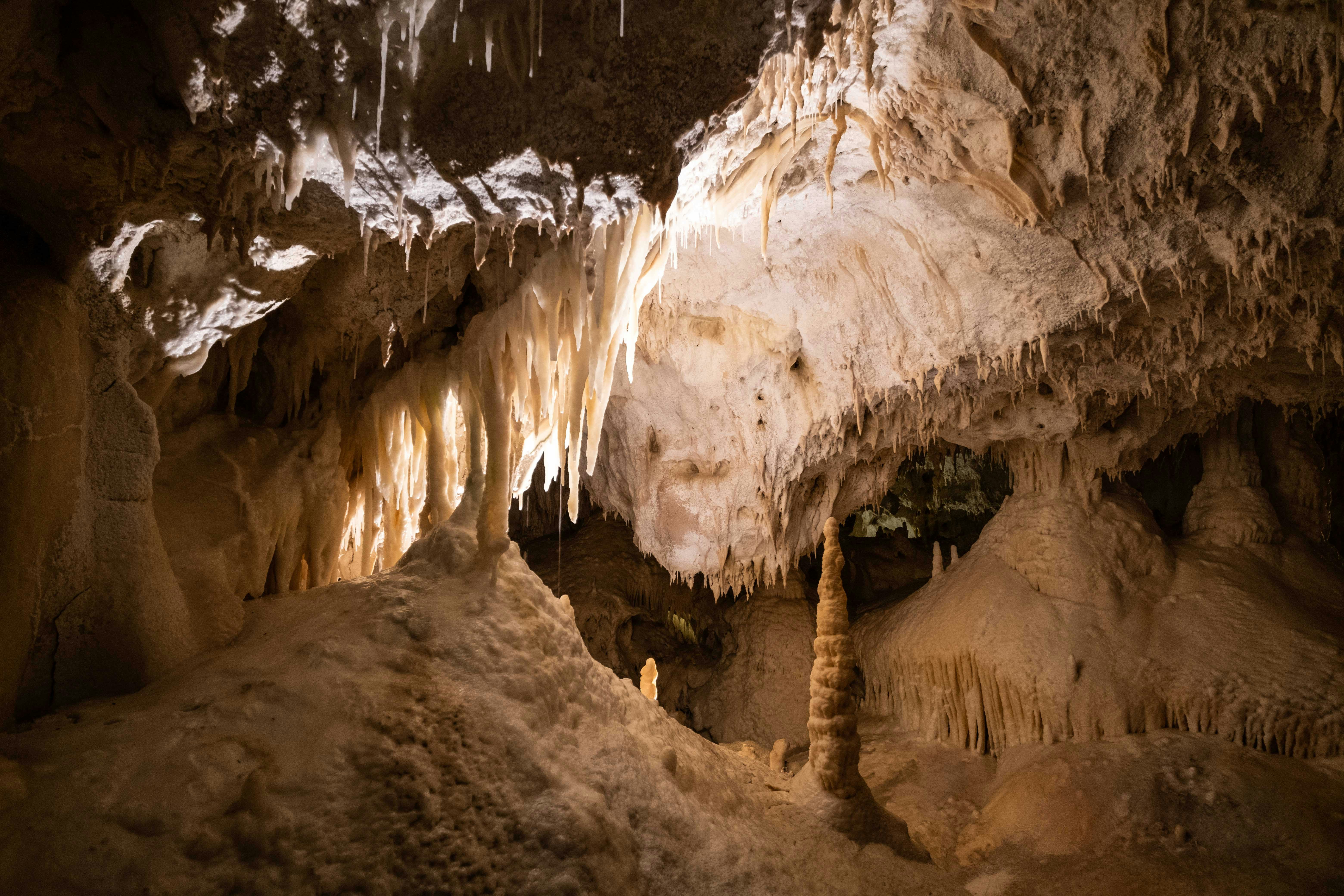 A cave filled with lots of ice hanging from the ceiling photo – Free ...