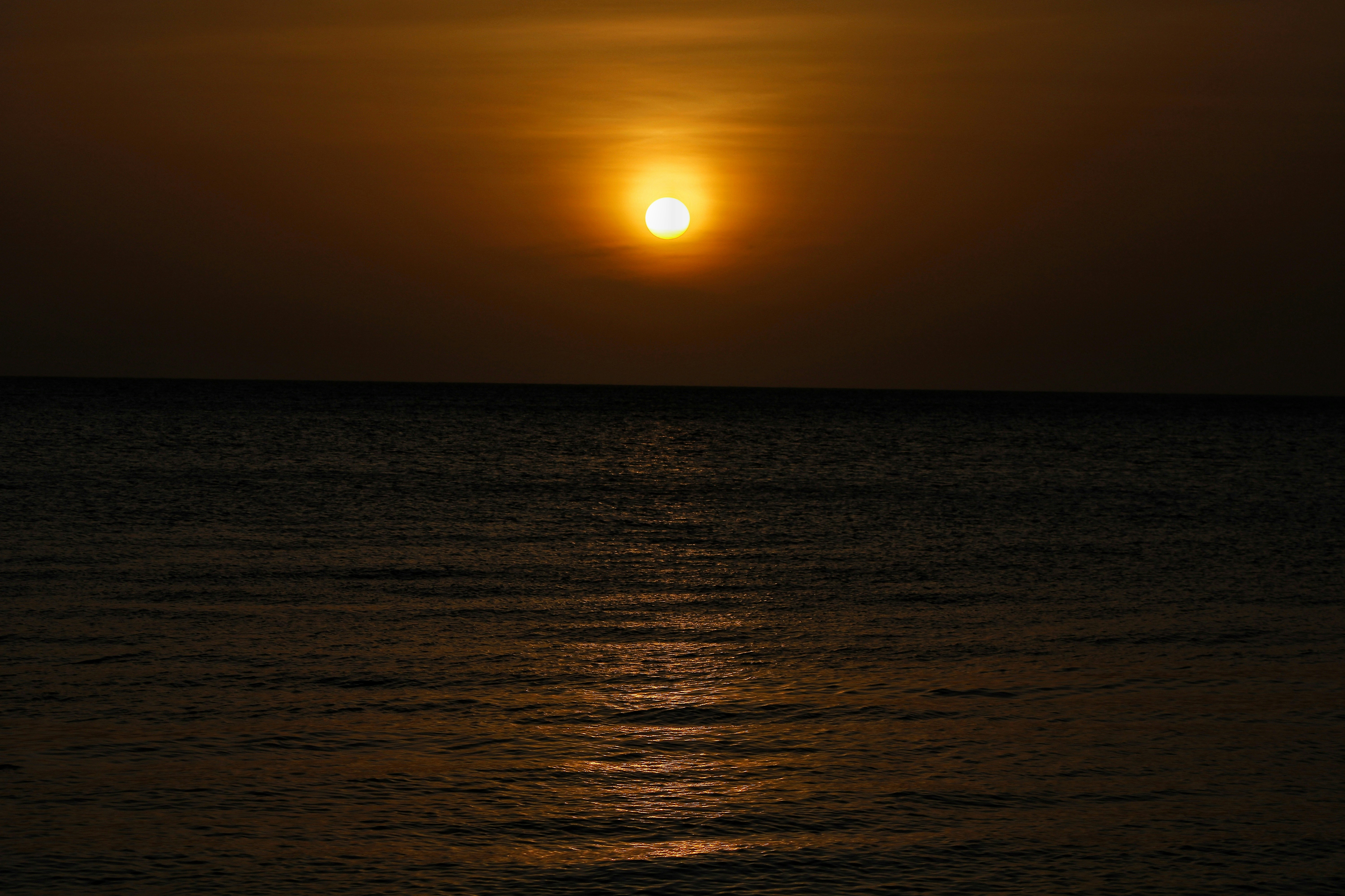 The sun is setting over the ocean on a cloudy day photo – Free Puerto ...