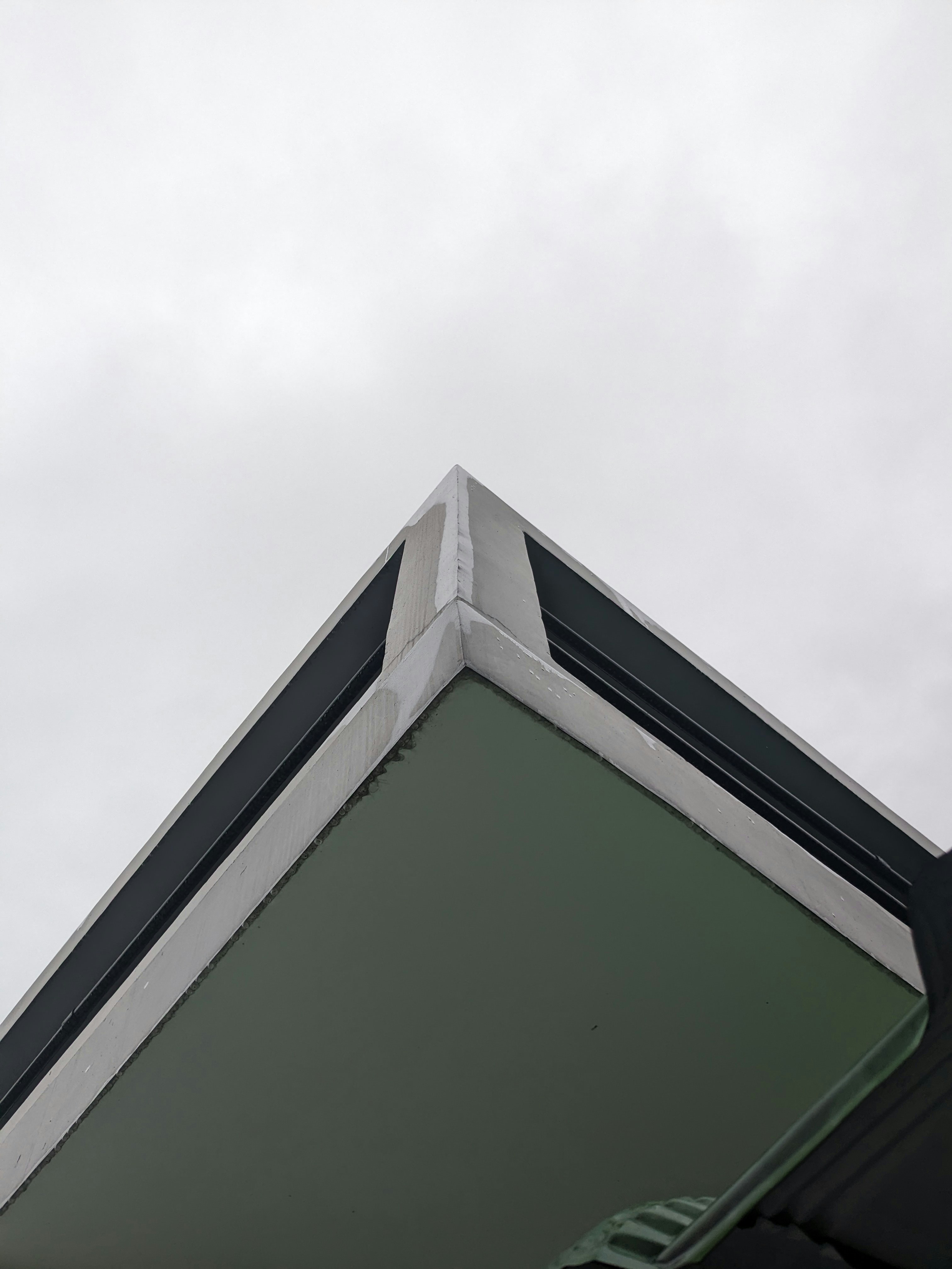 The Apex of Concrete: Sharp Corner Against a Gray Sky