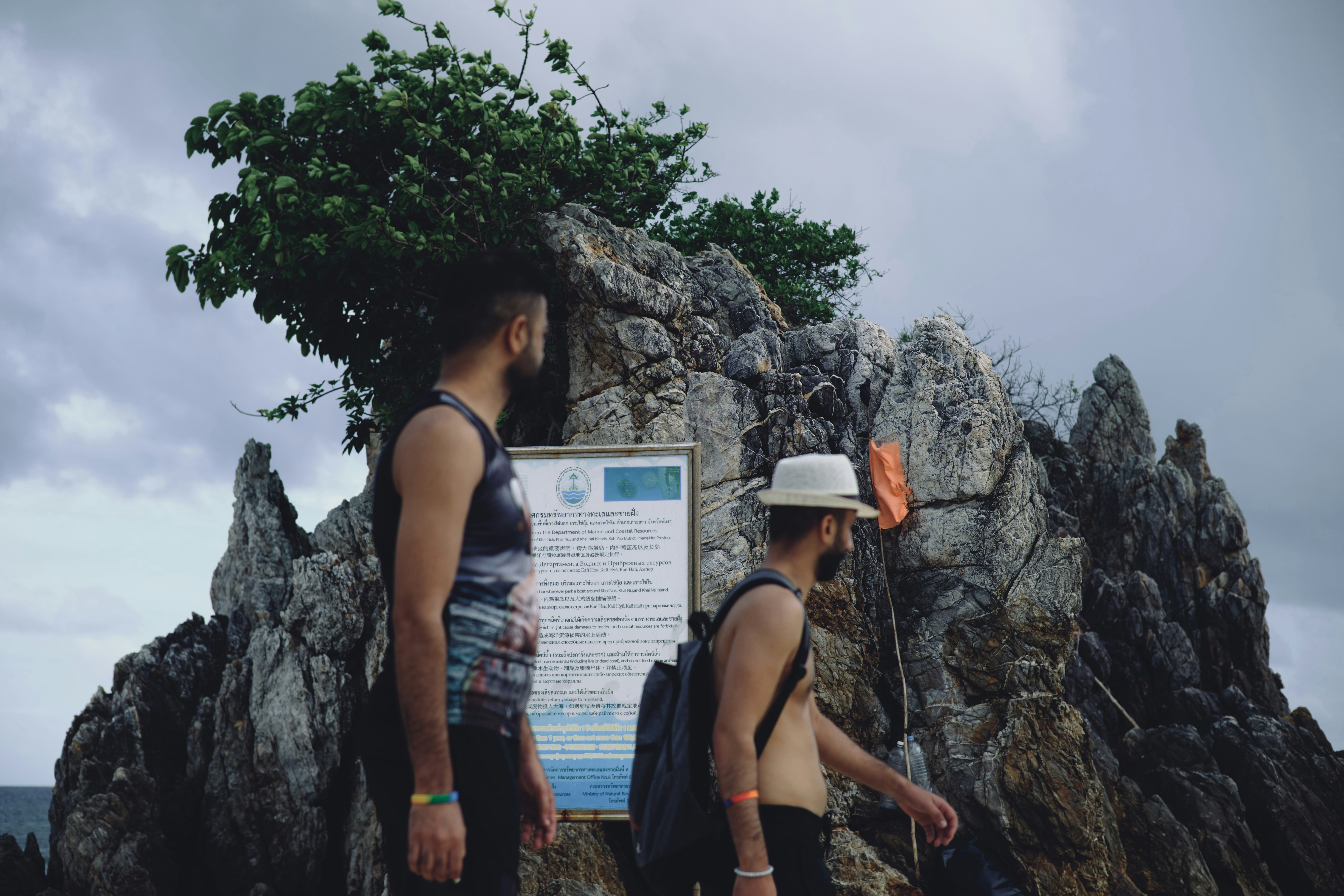 A couple of men standing next to a sign photo – Free Thailand Image on ...