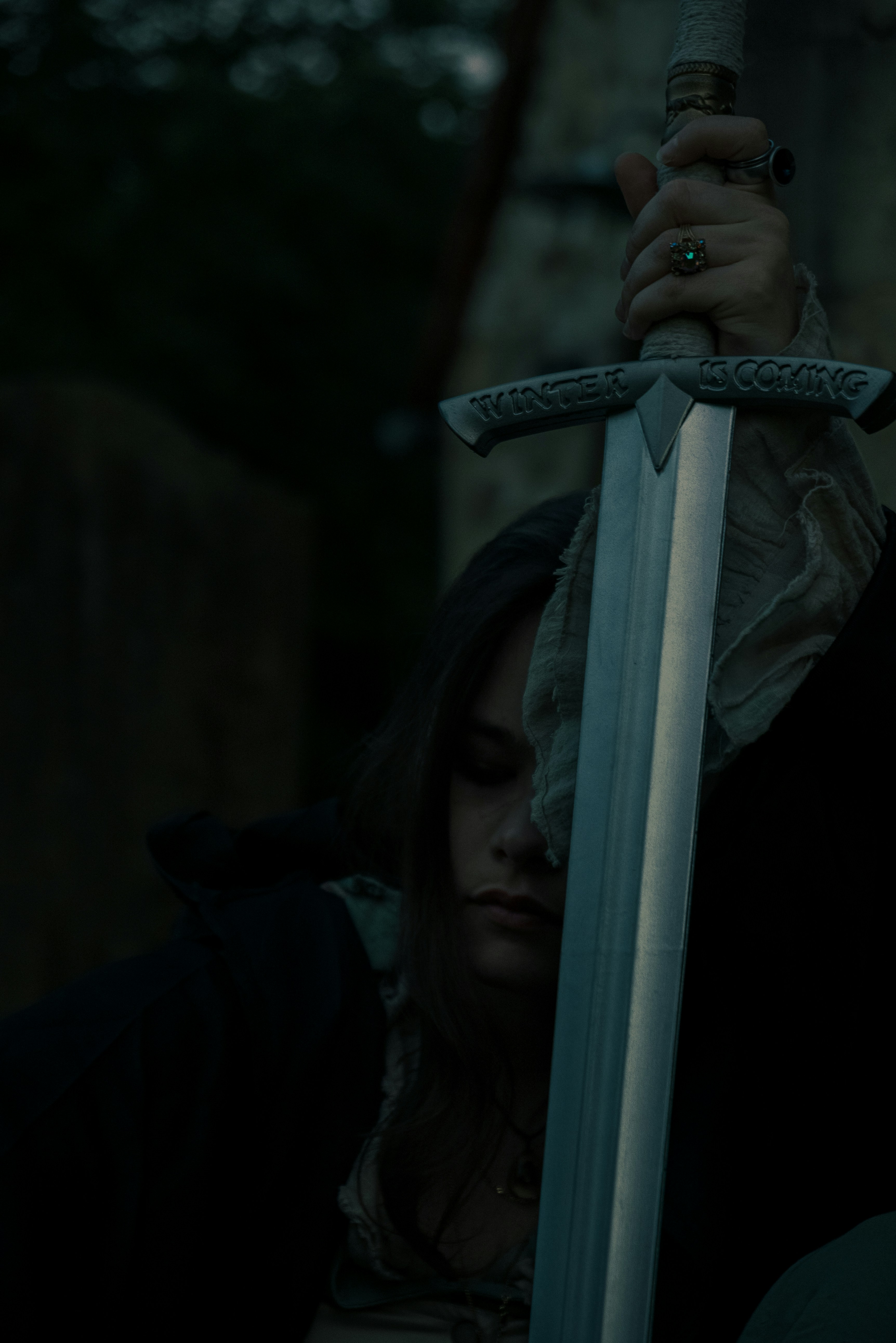 A woman holding a sword in a dark forest photo – Free Sword Image on ...