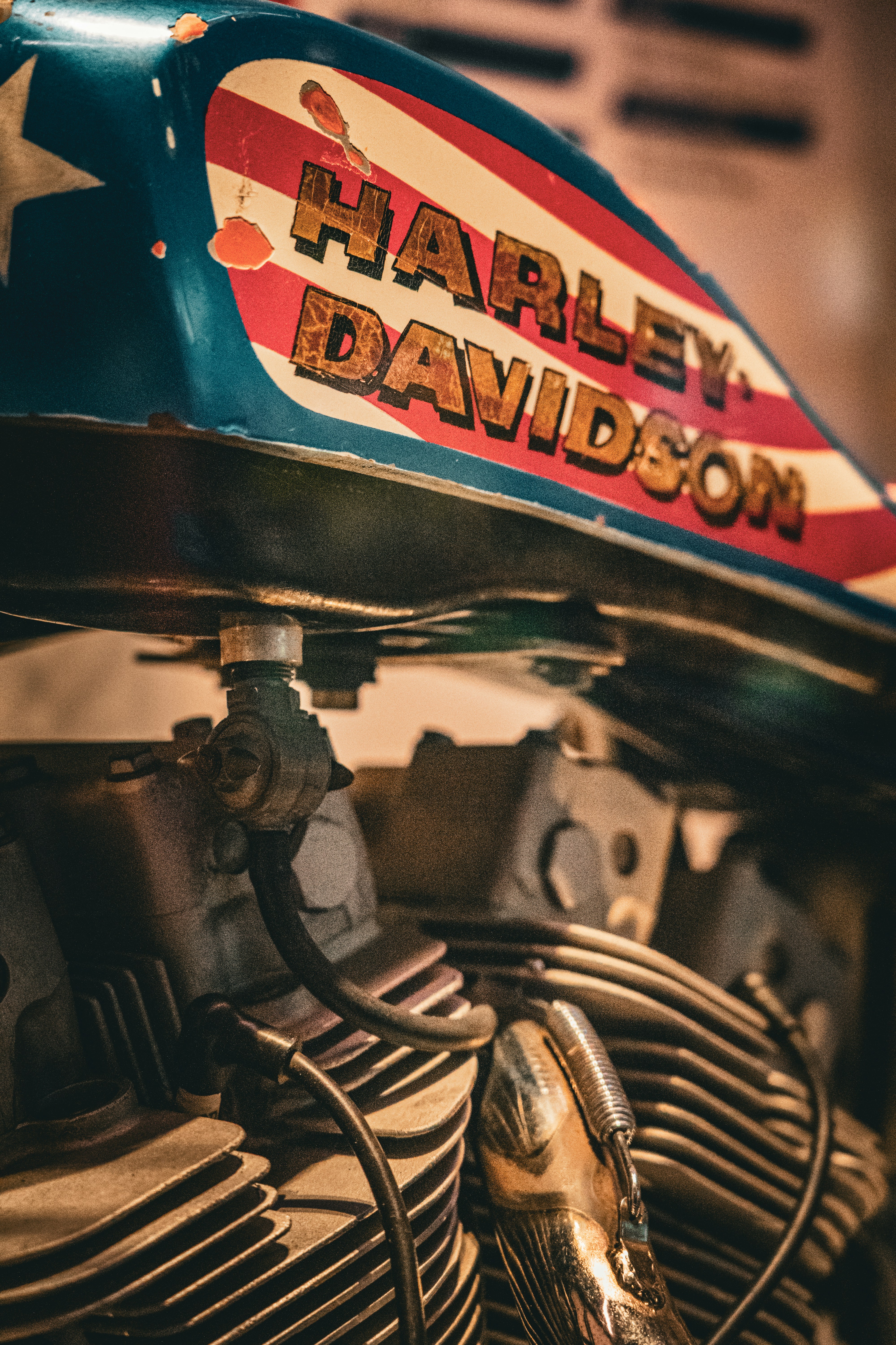 Close-Up Harley-Davidson Emblem on a Weathered Tank Under Warm Patina