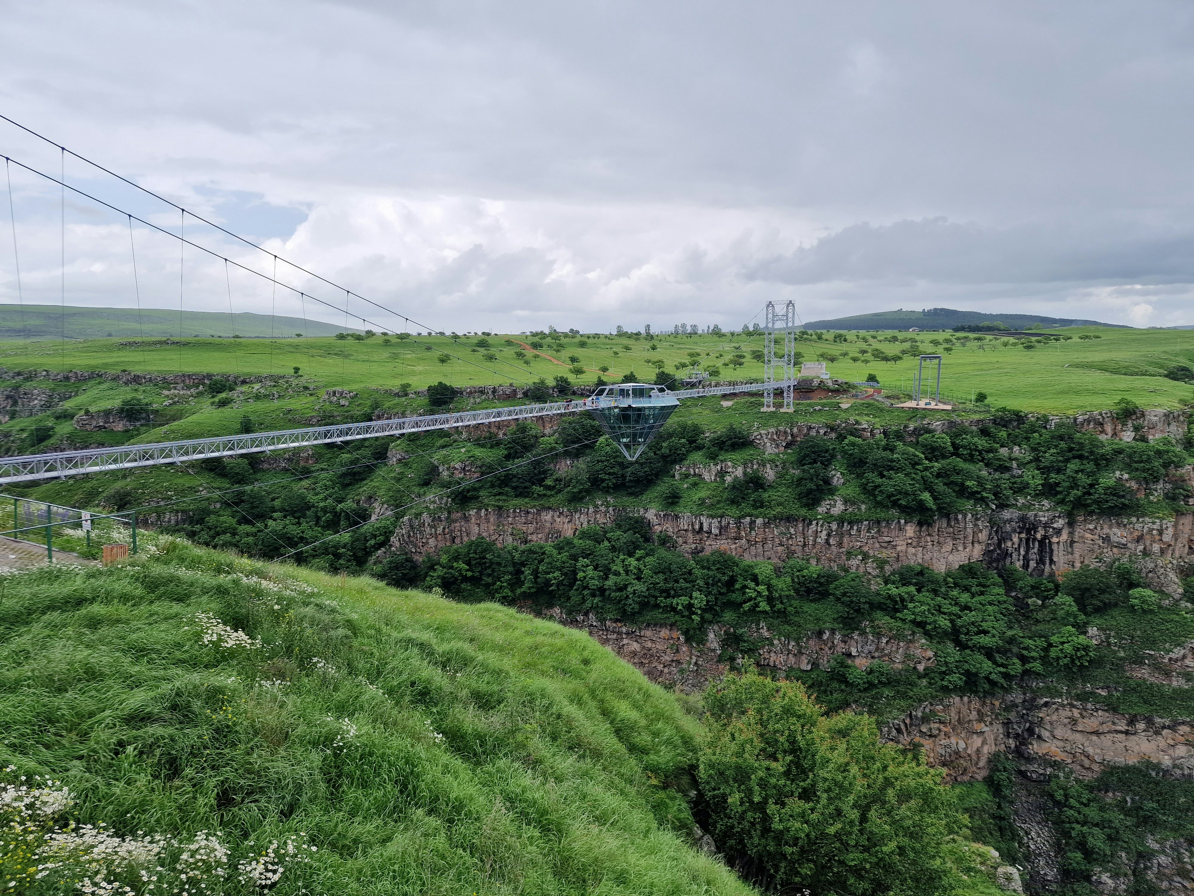 Across the Emerald Gorge: a suspended cable car glides between cliff walls