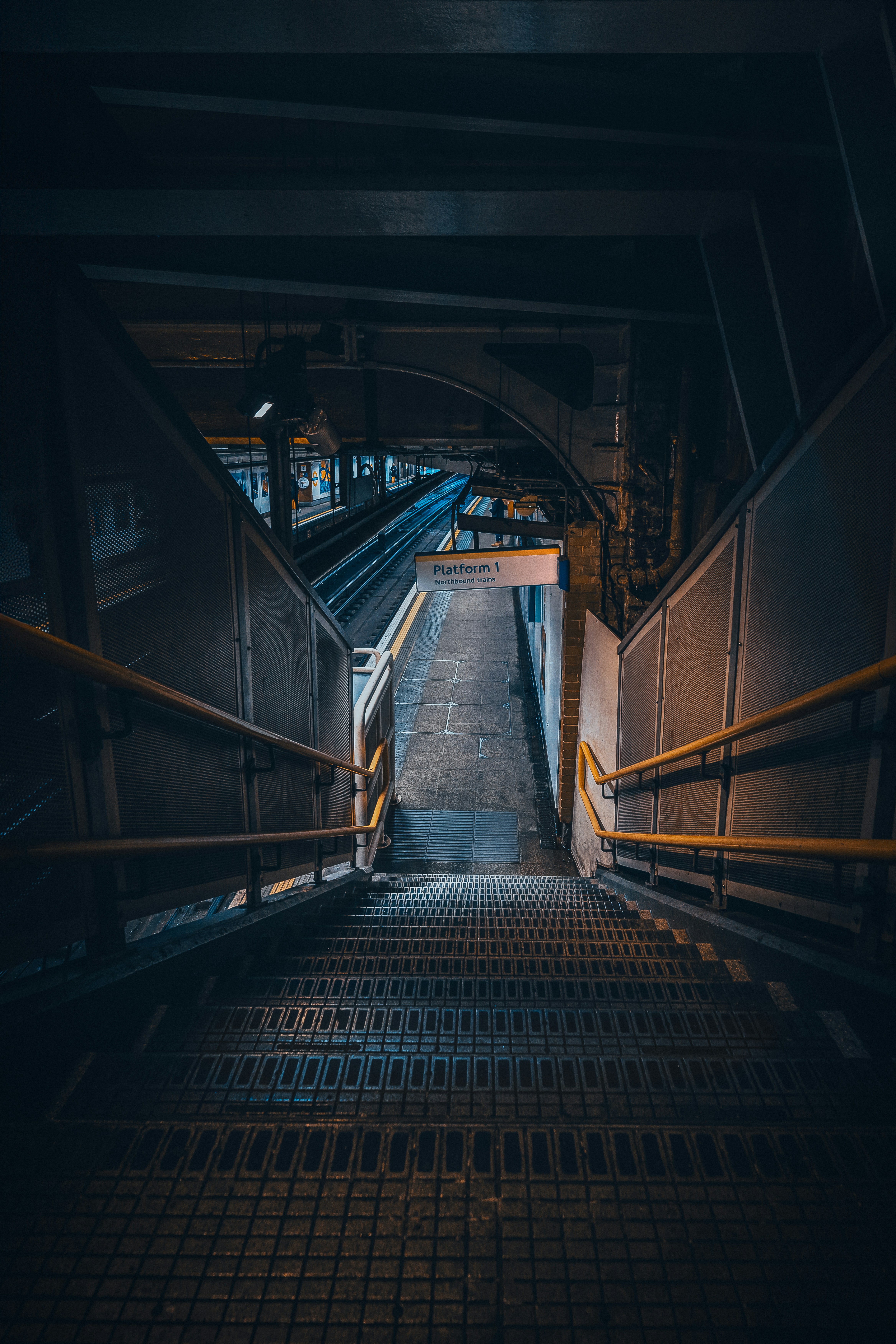 A stairway leading to a train station with yellow railings photo – Free ...