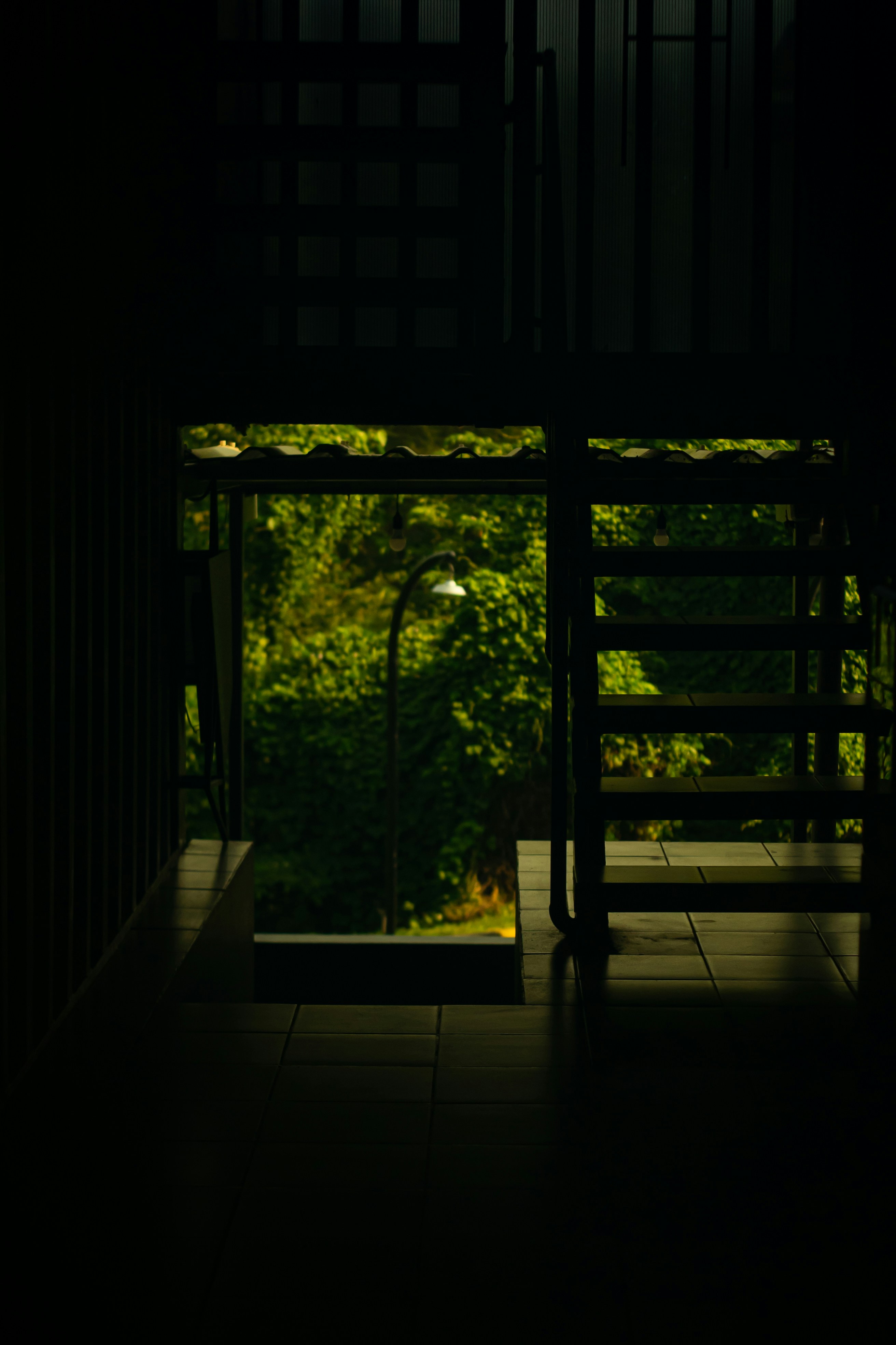 Threshold to Daylight: A Shadowed Corridor Opens onto a Sunlit Courtyard