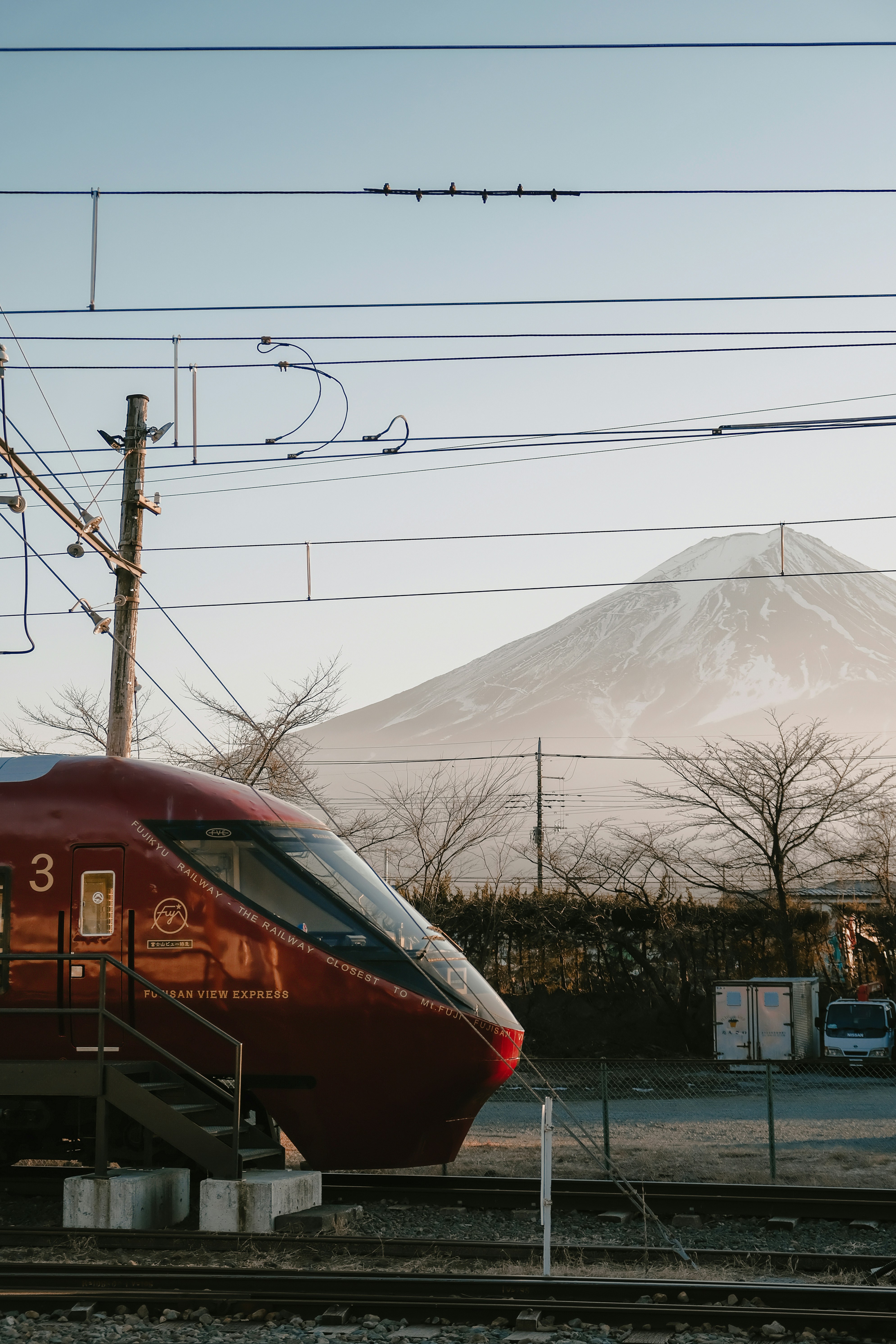 A red train traveling past a snow covered mountain photo – Free Train ...