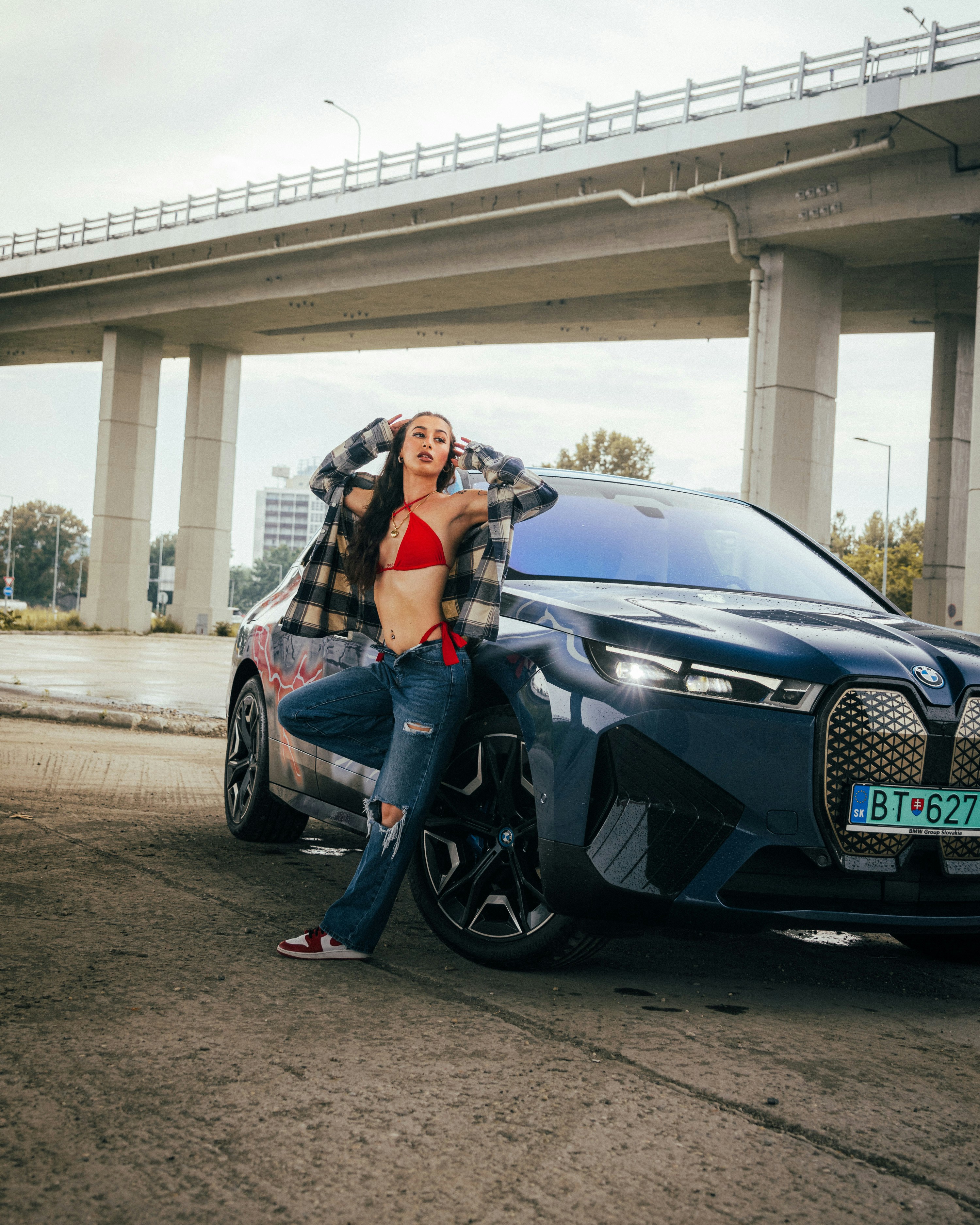 Red Car, Bold Attitude: Woman in Red Bikini and Flannel Leaning by Front Grille