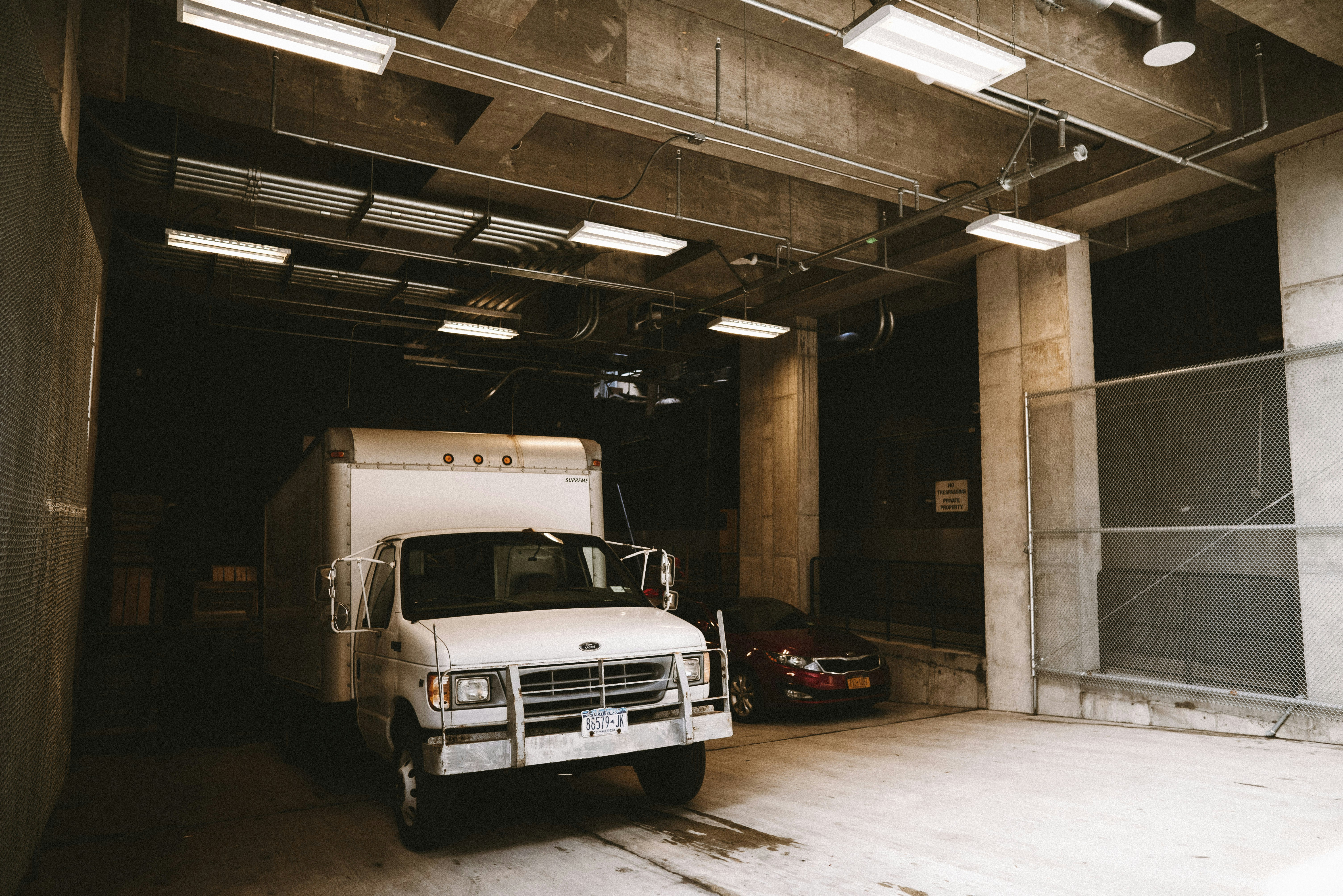 Dim Corridor, White Courier: A Quiet Moment in an Industrial Garage