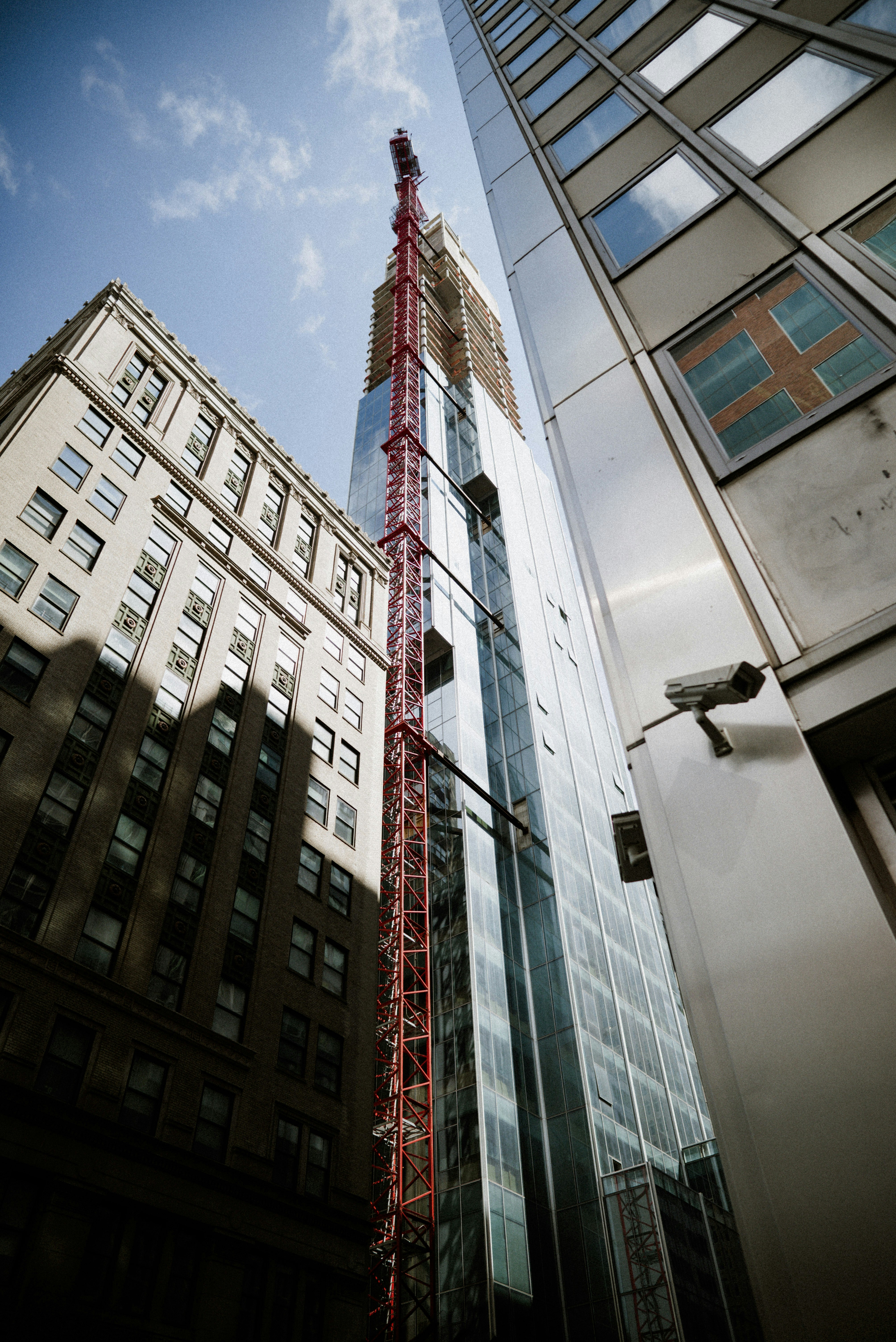 Red Crane Ascends Between Glass Towers