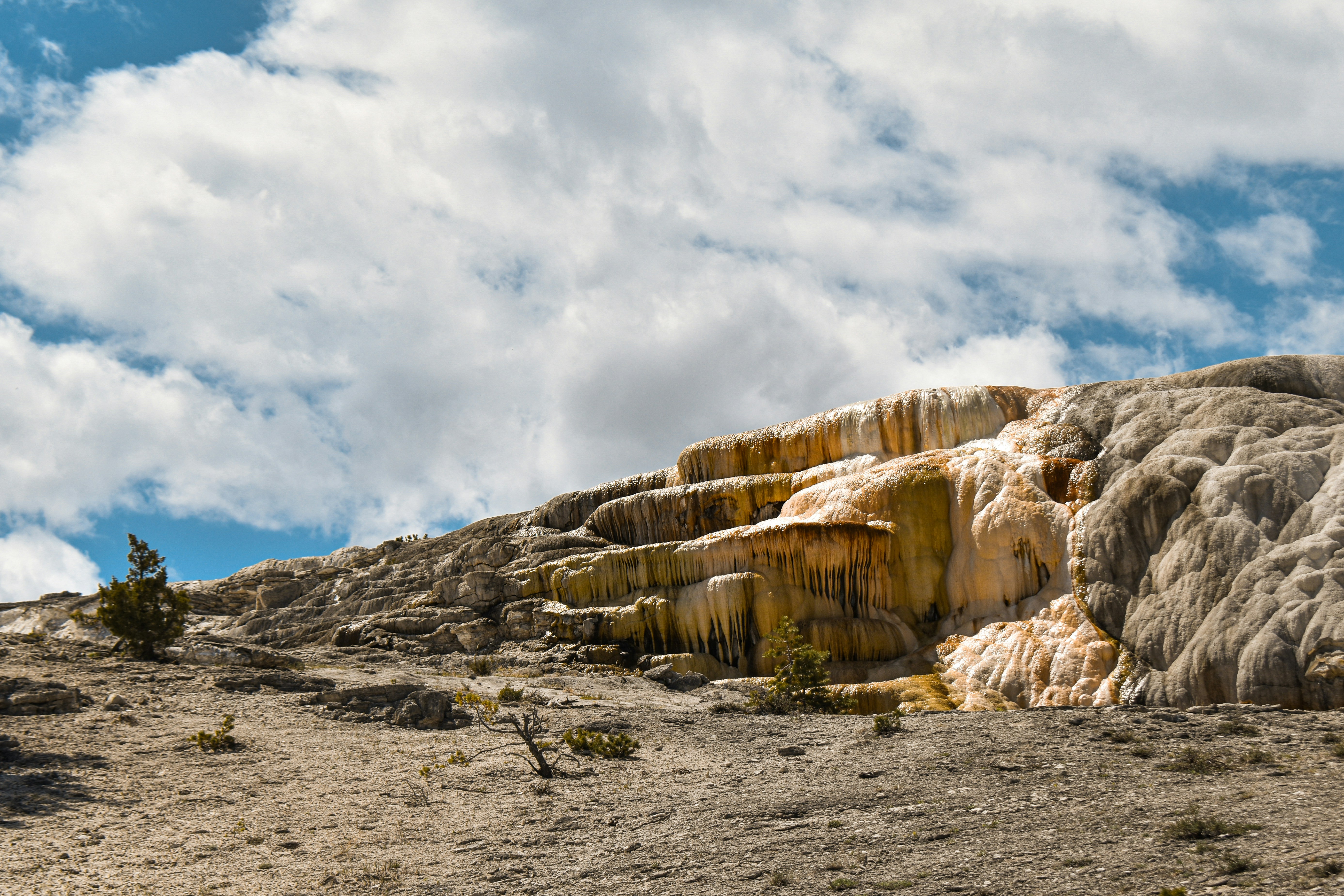 A rocky outcropping in the desert under a cloudy blue sky photo – Free ...