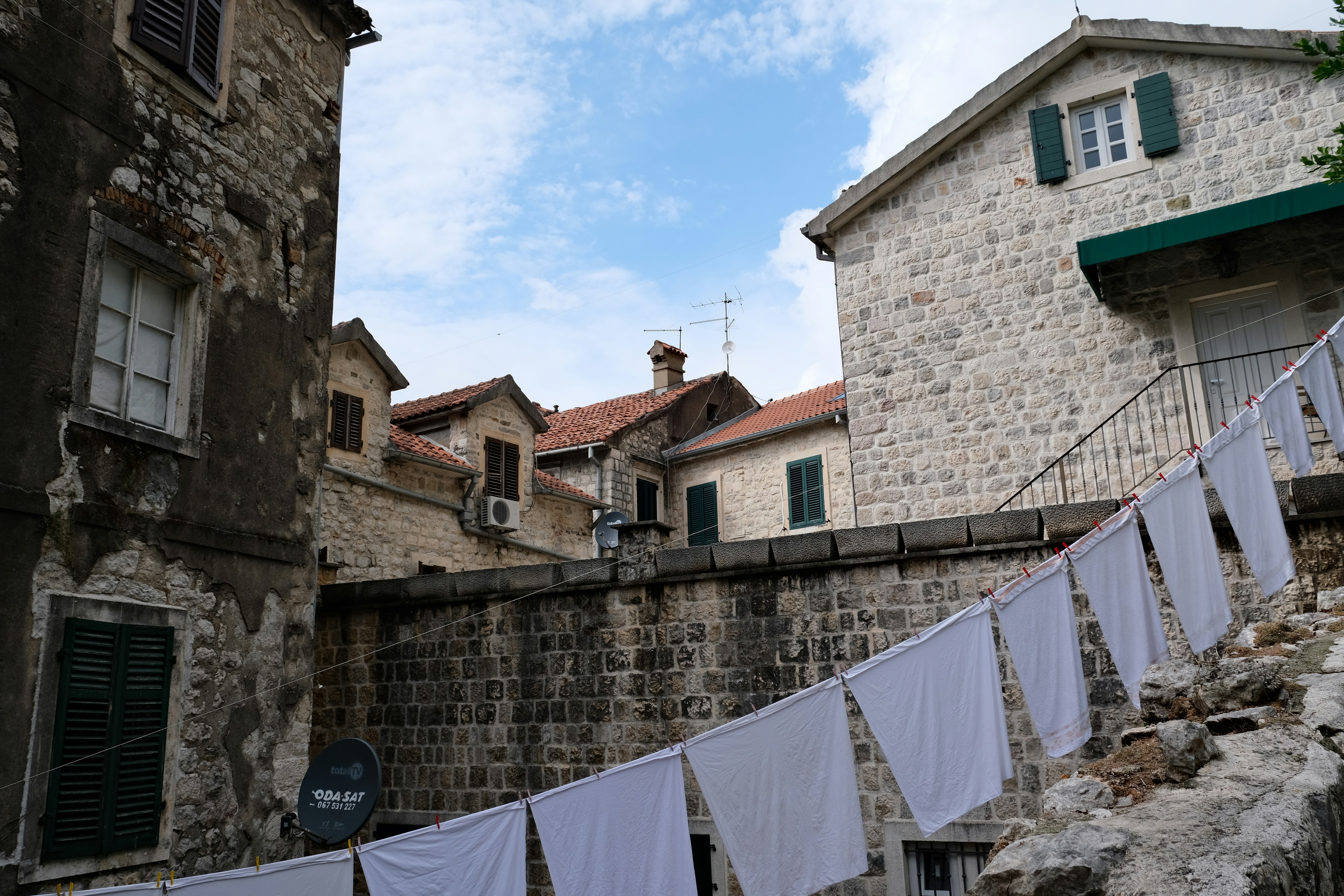 Diagonal Laundry Across a Sunlit Stone Courtyard