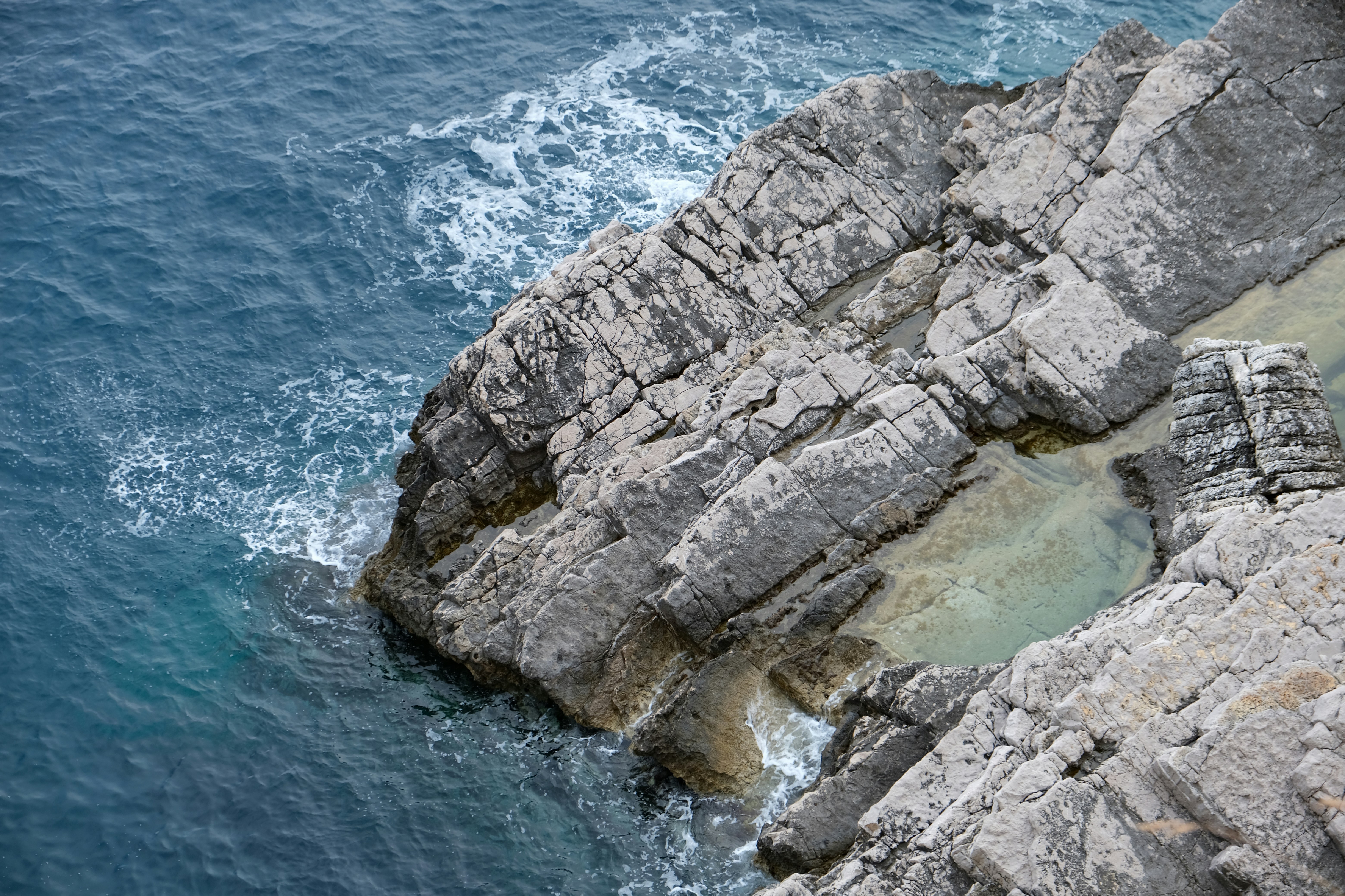 A rock outcropping in the middle of the ocean photo – Free Petrovac ...