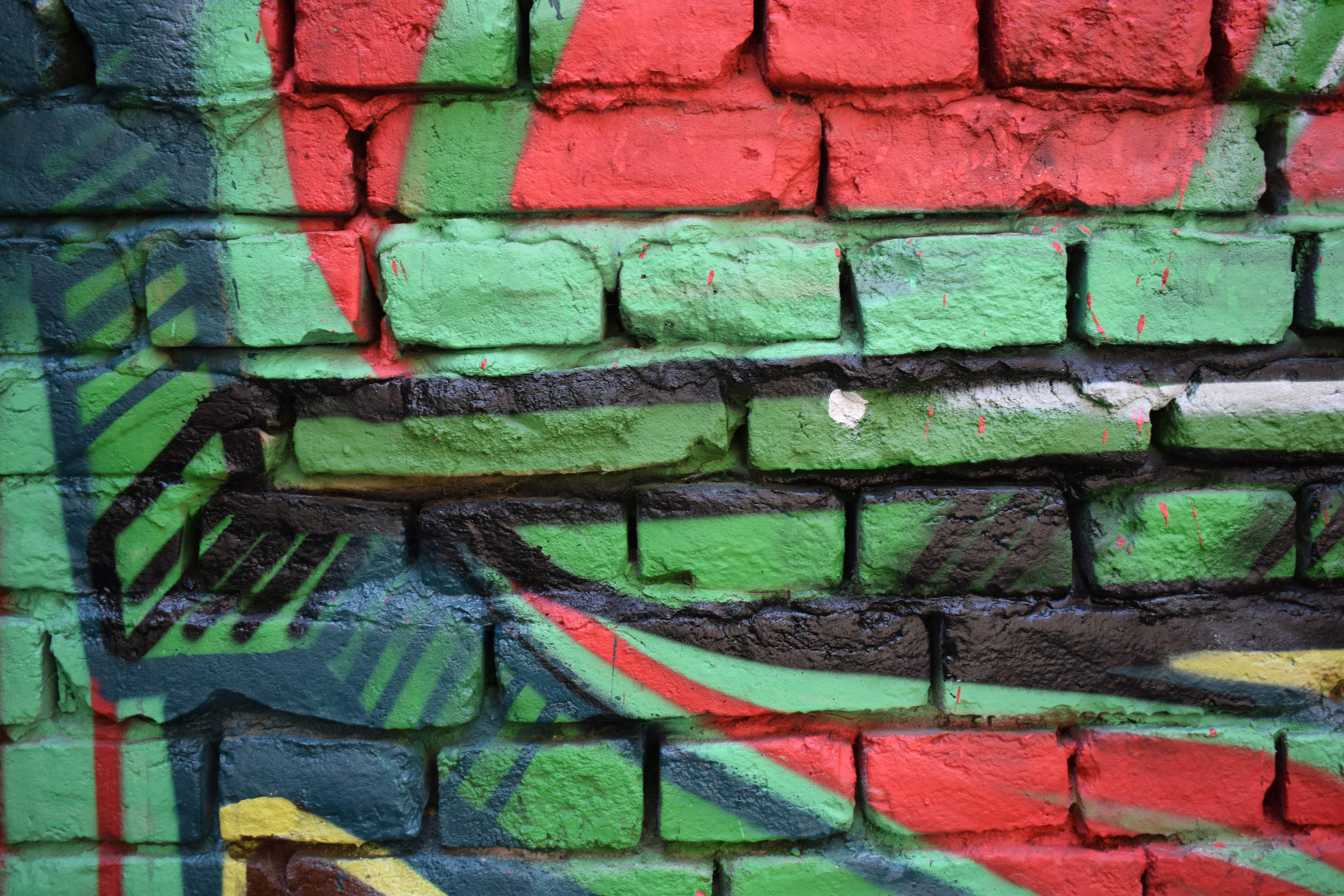 Neon Verdure Across Weathered Masonry: A Graffiti Tapestry in Green and Red