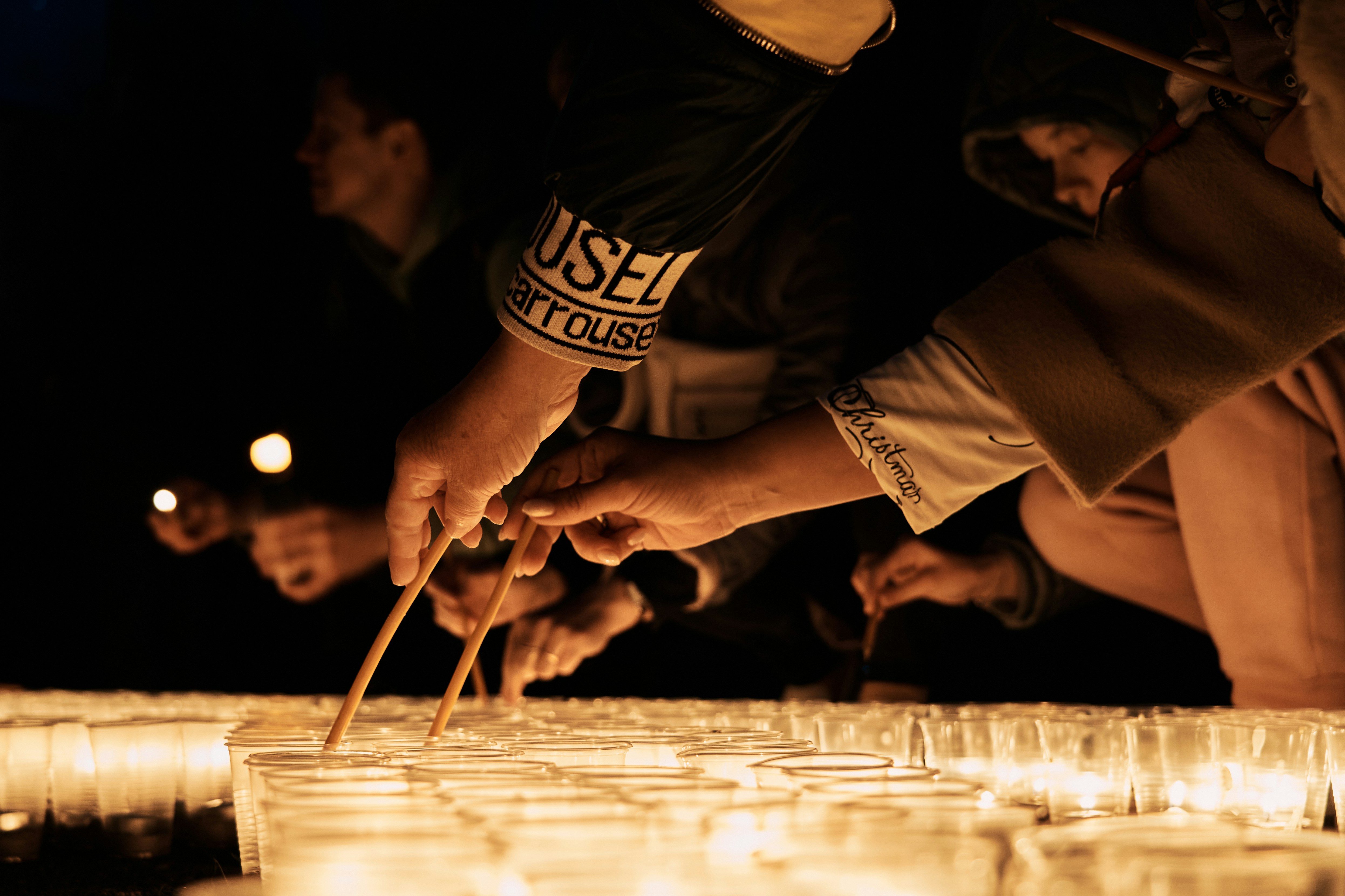Hands in the Glow: A Shared Moment of Candlelit Focus