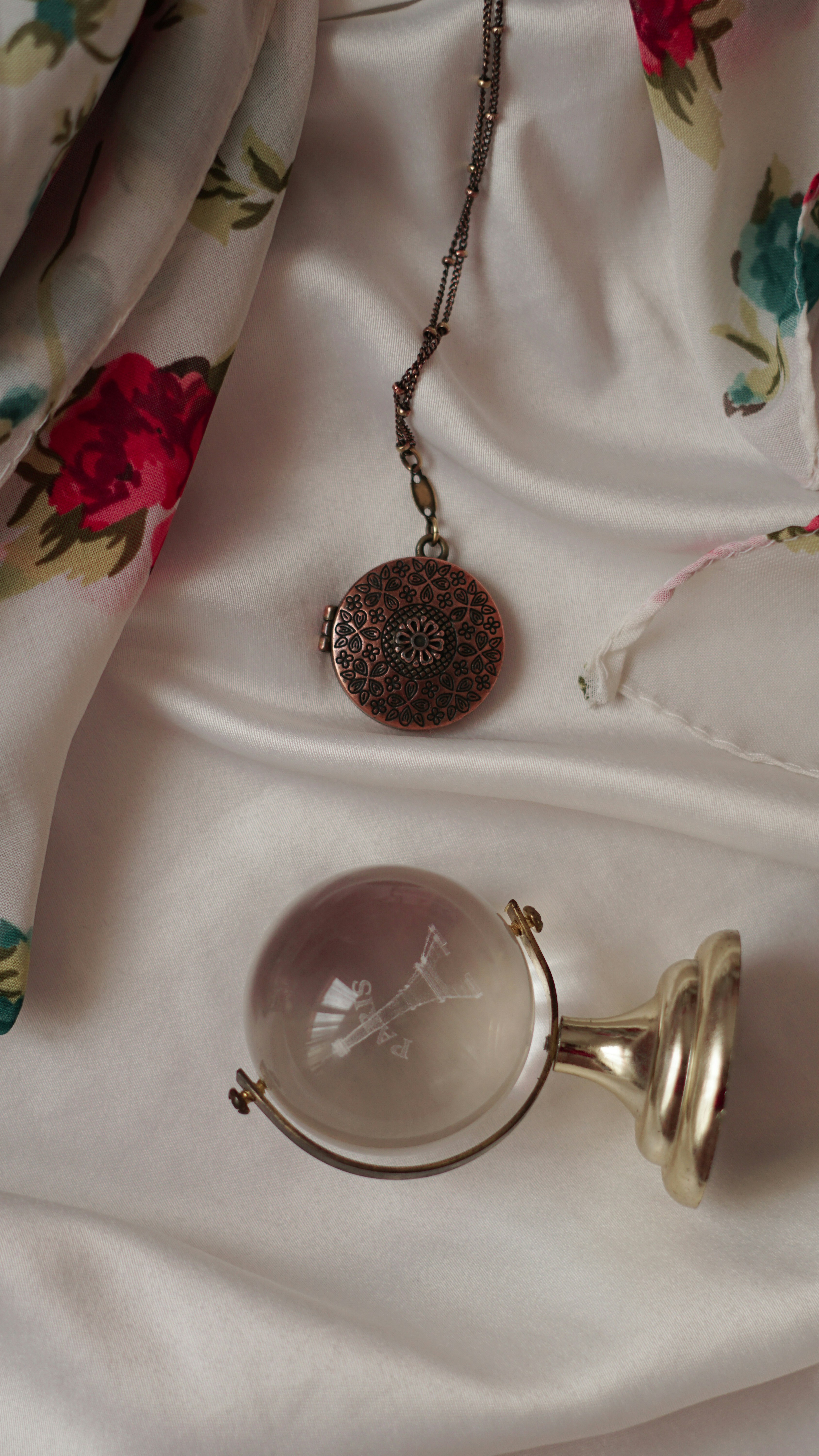 Ornate Copper Locket on Floral Silk: A Quiet Still-Life Moment