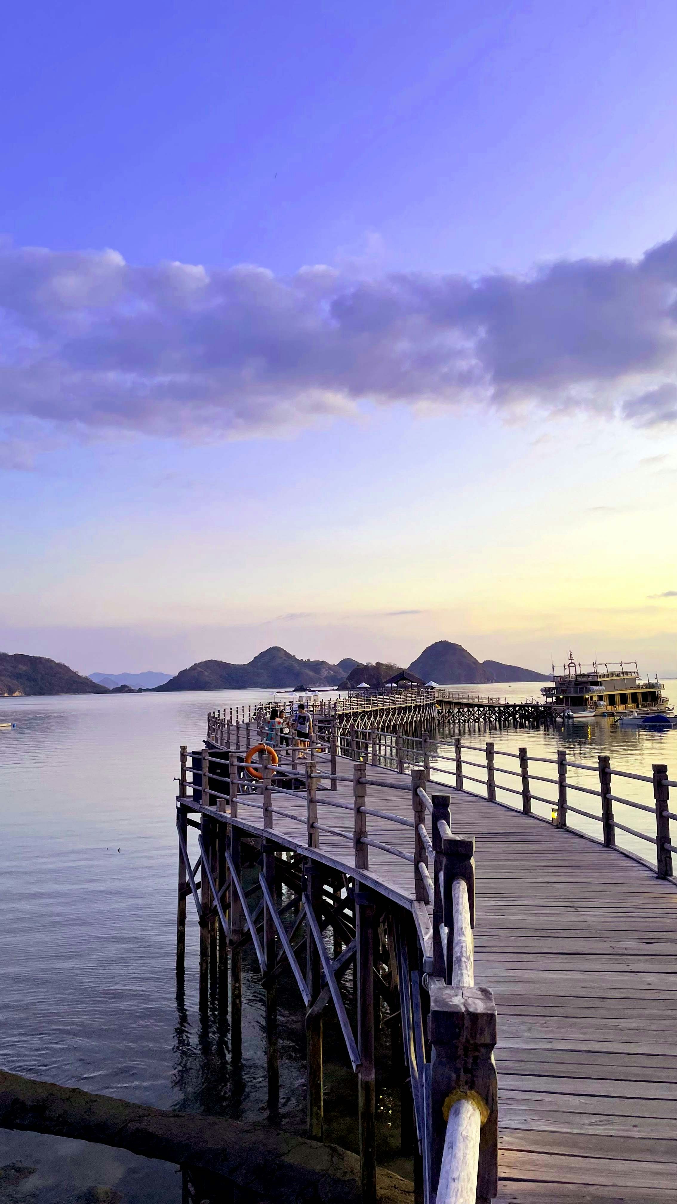 A pier with a boat in the water photo – Free Labuan bajo Image on Unsplash