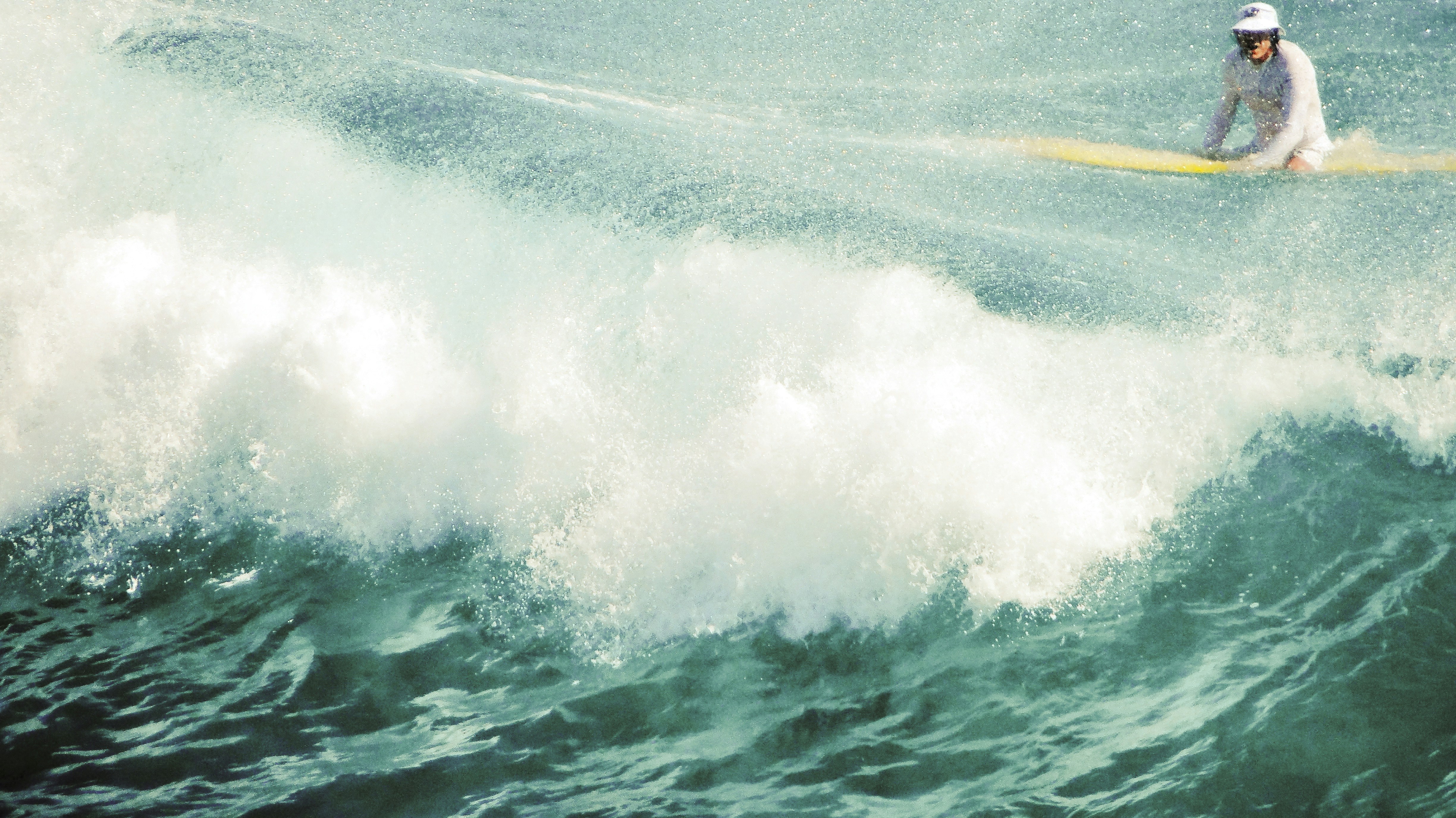 Teal Crest Rider: Surfer Navigates a White‑Foamed Break
