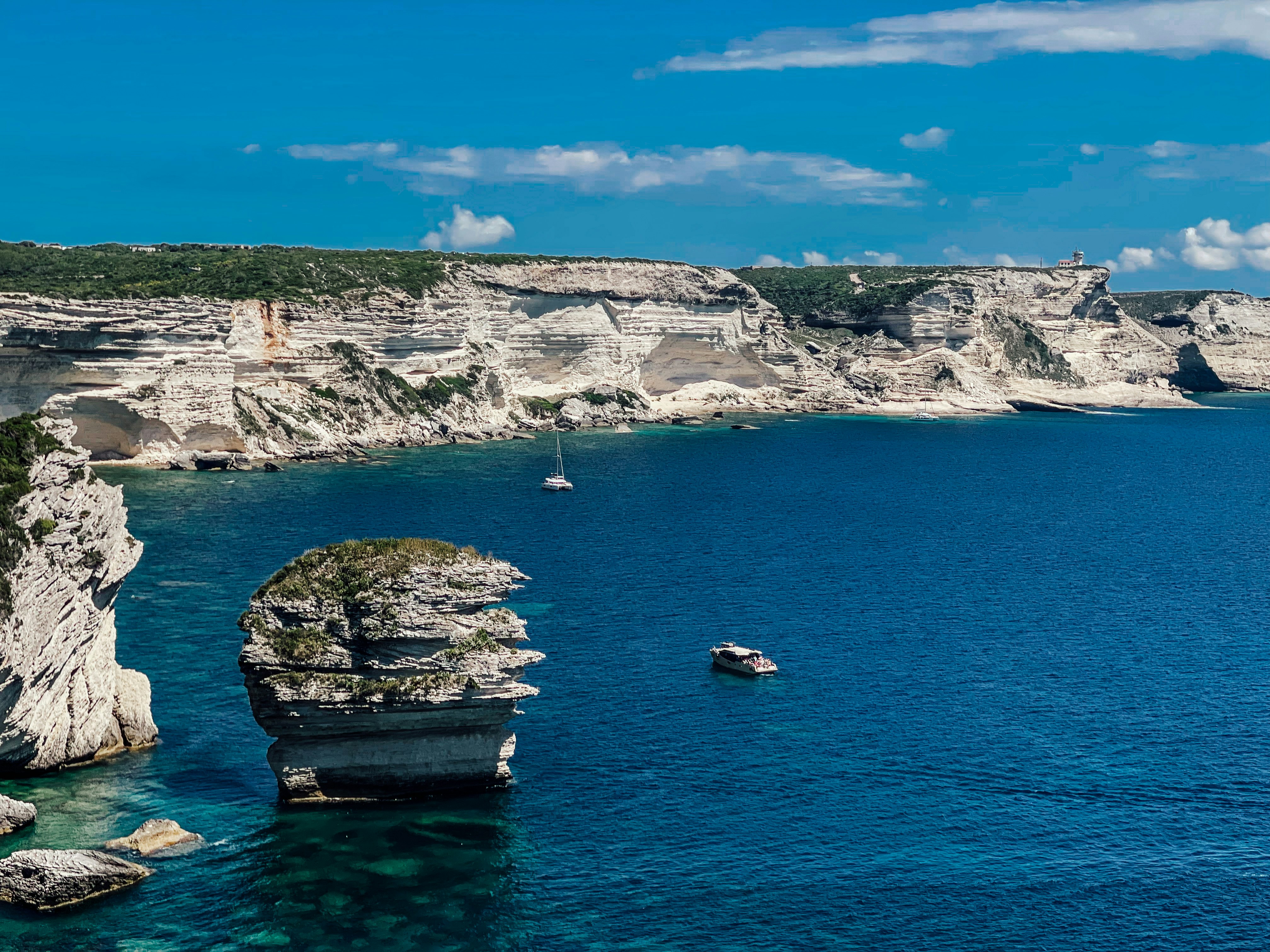 Azure Cliffs and Lone Boat under a Clear Sky