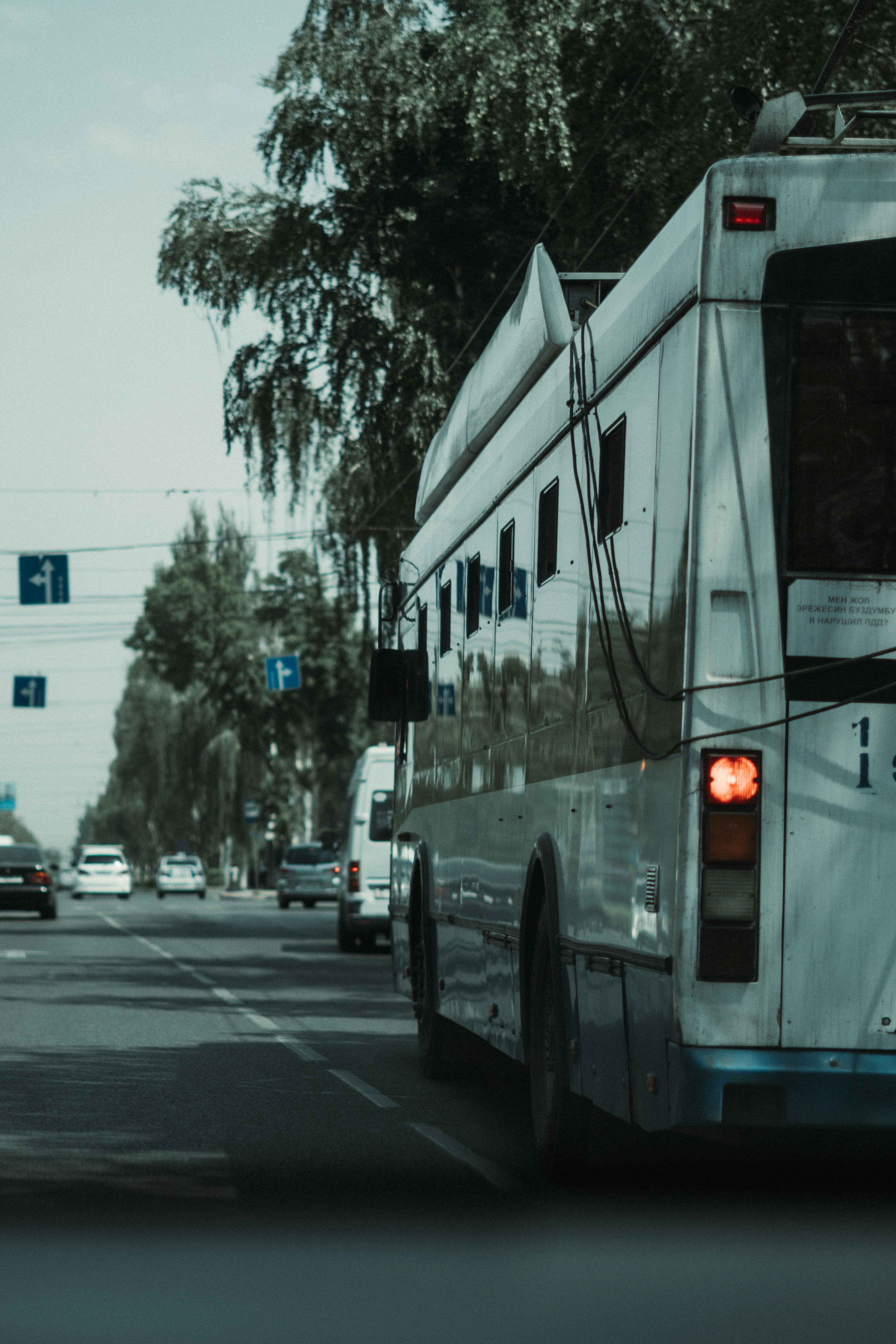Un bus blanc roulant dans une rue à côté d’un feu de circulation photo ...
