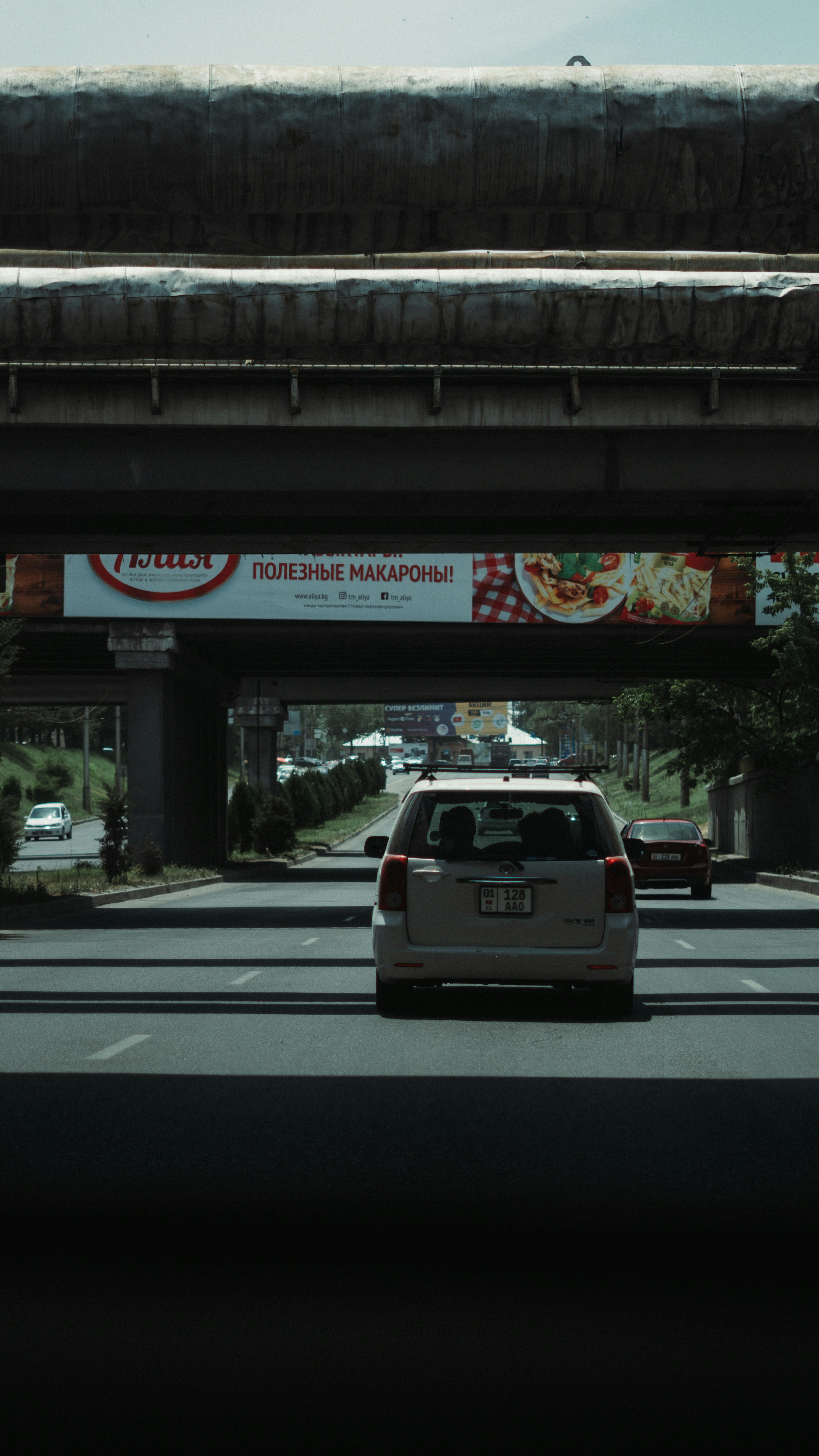 White Minivan Under Concrete Arches: A Quiet Urban Moment