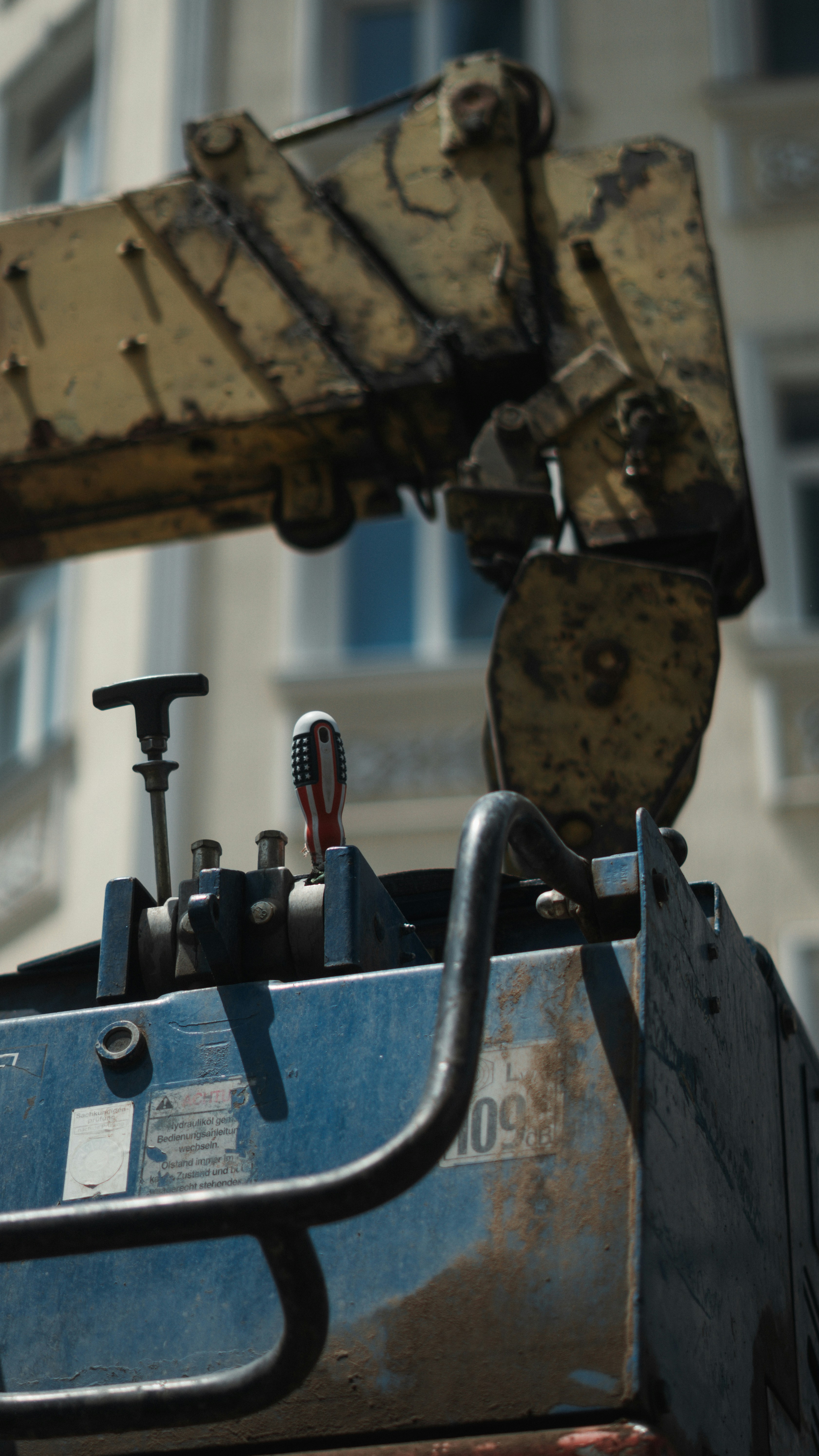 Red Lever Over Blue Steel: A Gritty Close-Up of Industrial Hardware