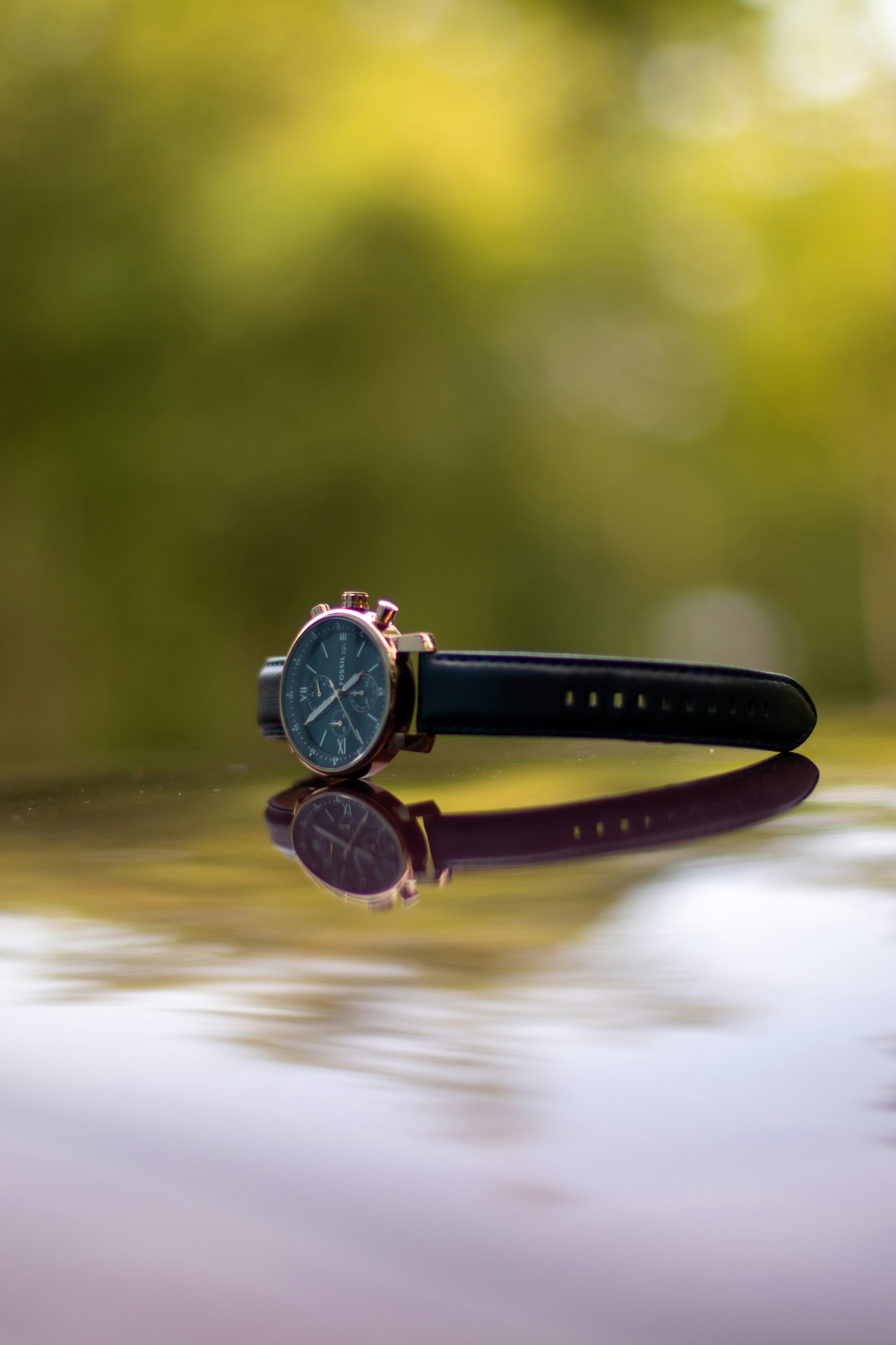 Rose-Gold Chronograph Resting on a Glassy Surface