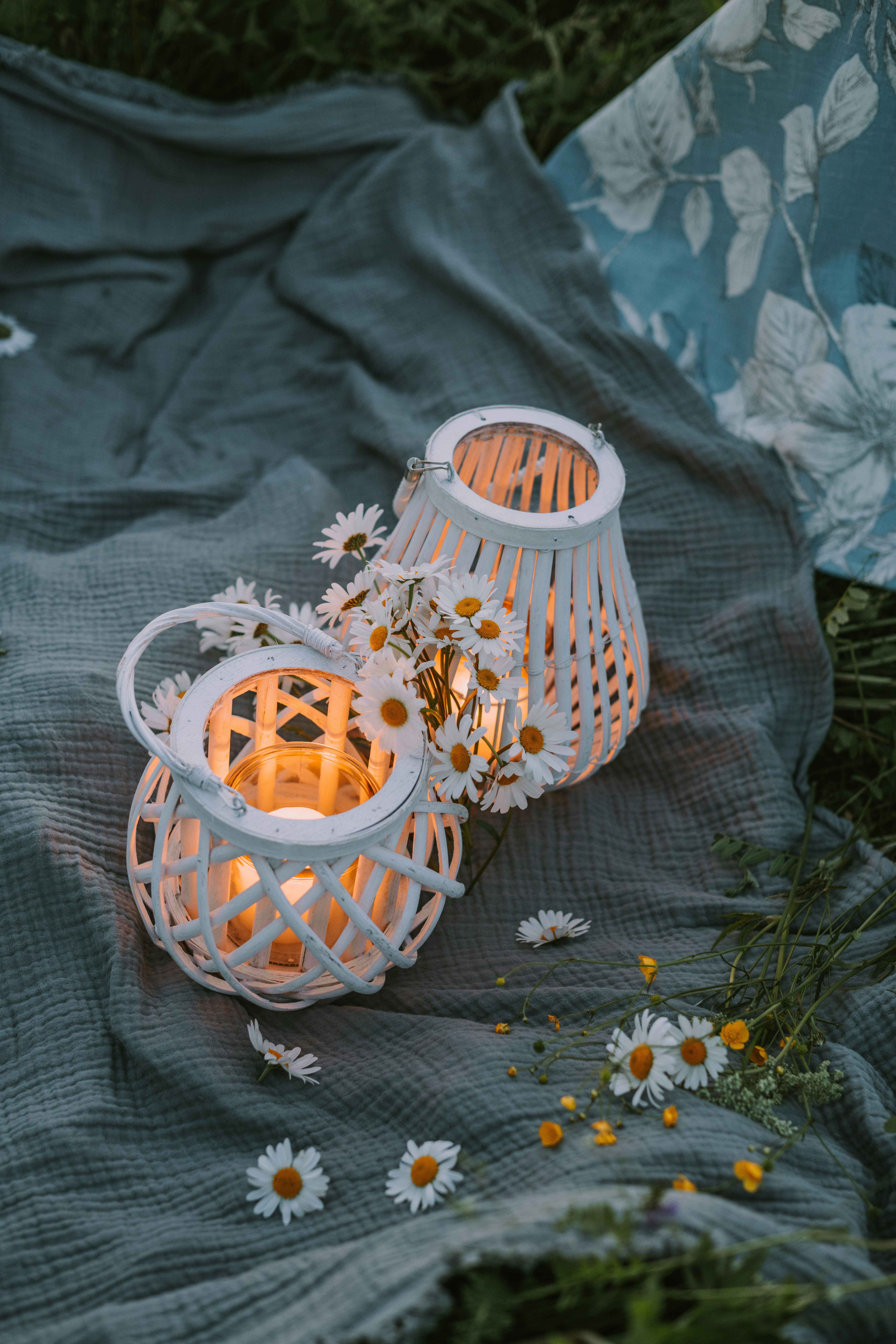 a couple of white candles sitting on top of a blanket