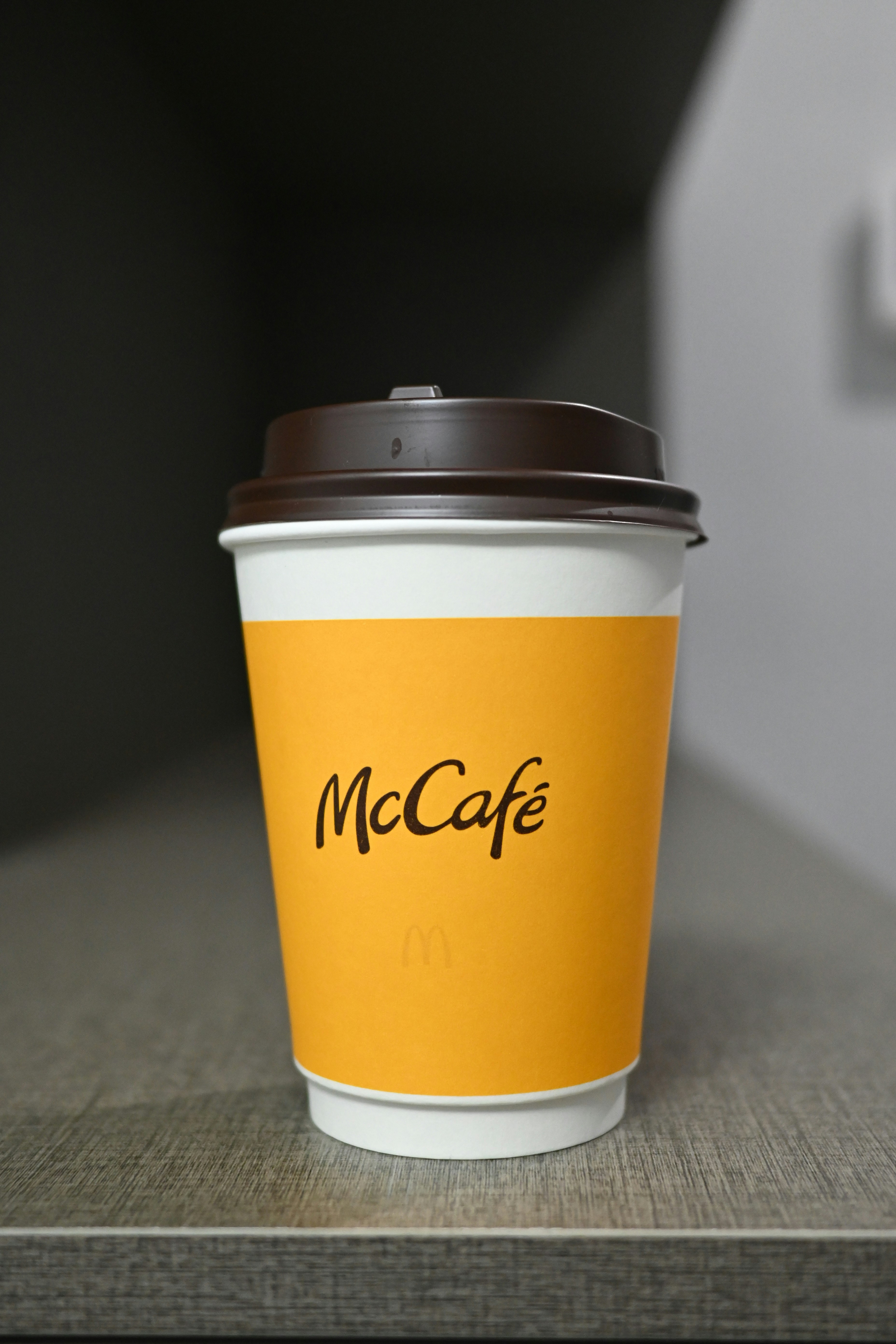 Shallow-Depth Focus on a McCafé Cup: Bold Yellow Sleeve on a Quiet Counter