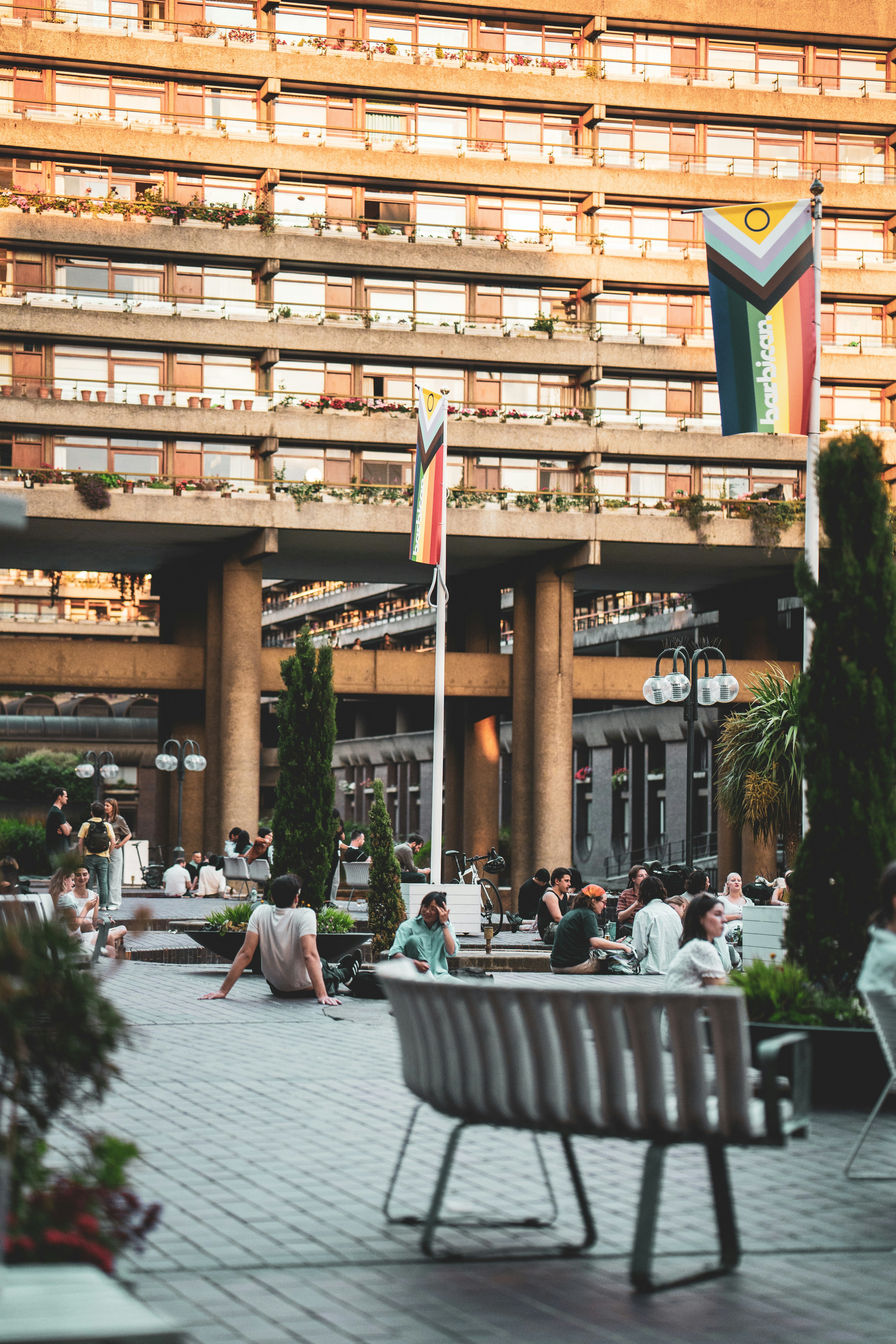 A group of people sitting and standing around a building photo – Free ...