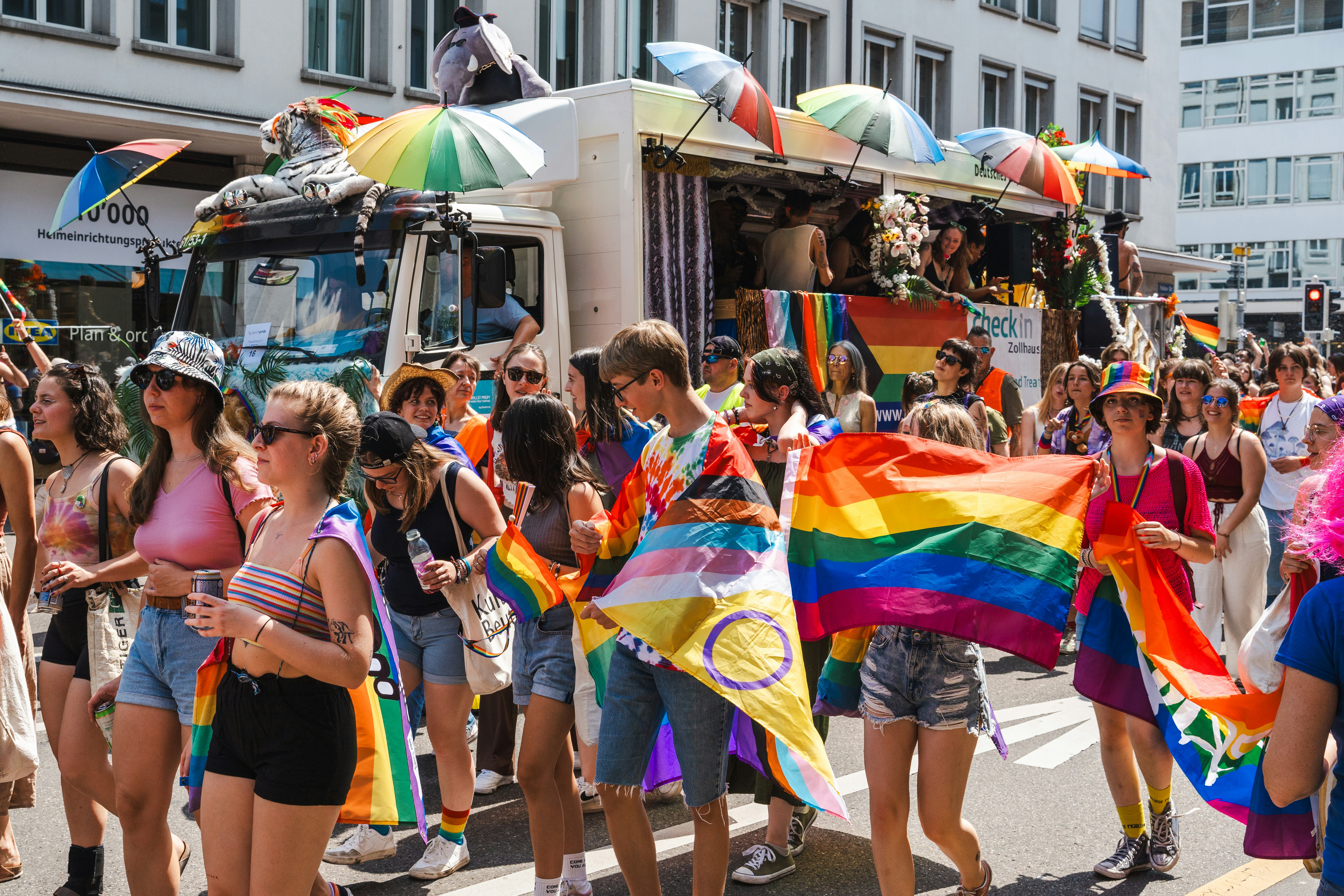 A group of people walking down a street holding rainbow flags photo ...