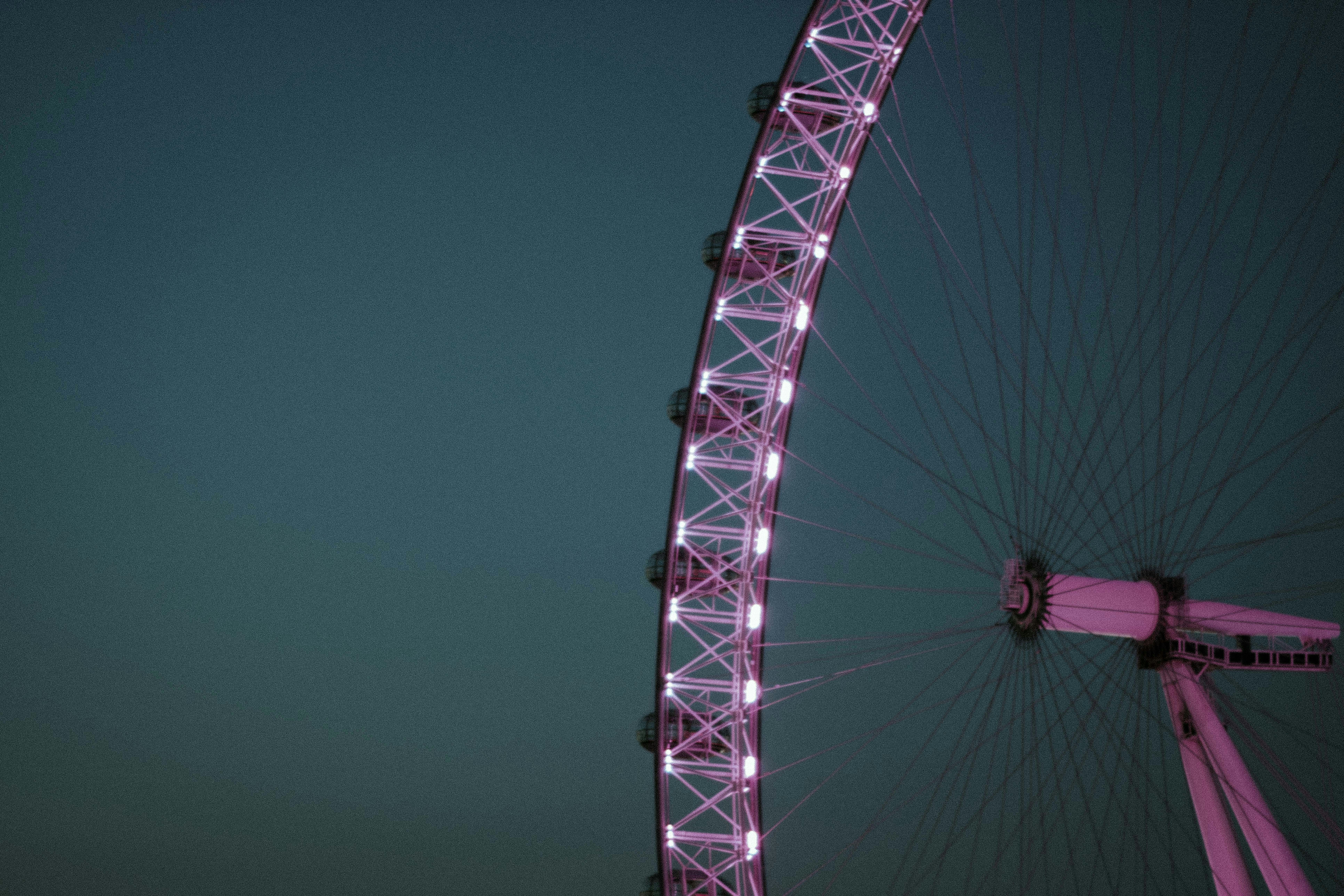 Neon Spokes: a segment of the illuminated Ferris wheel at dusk