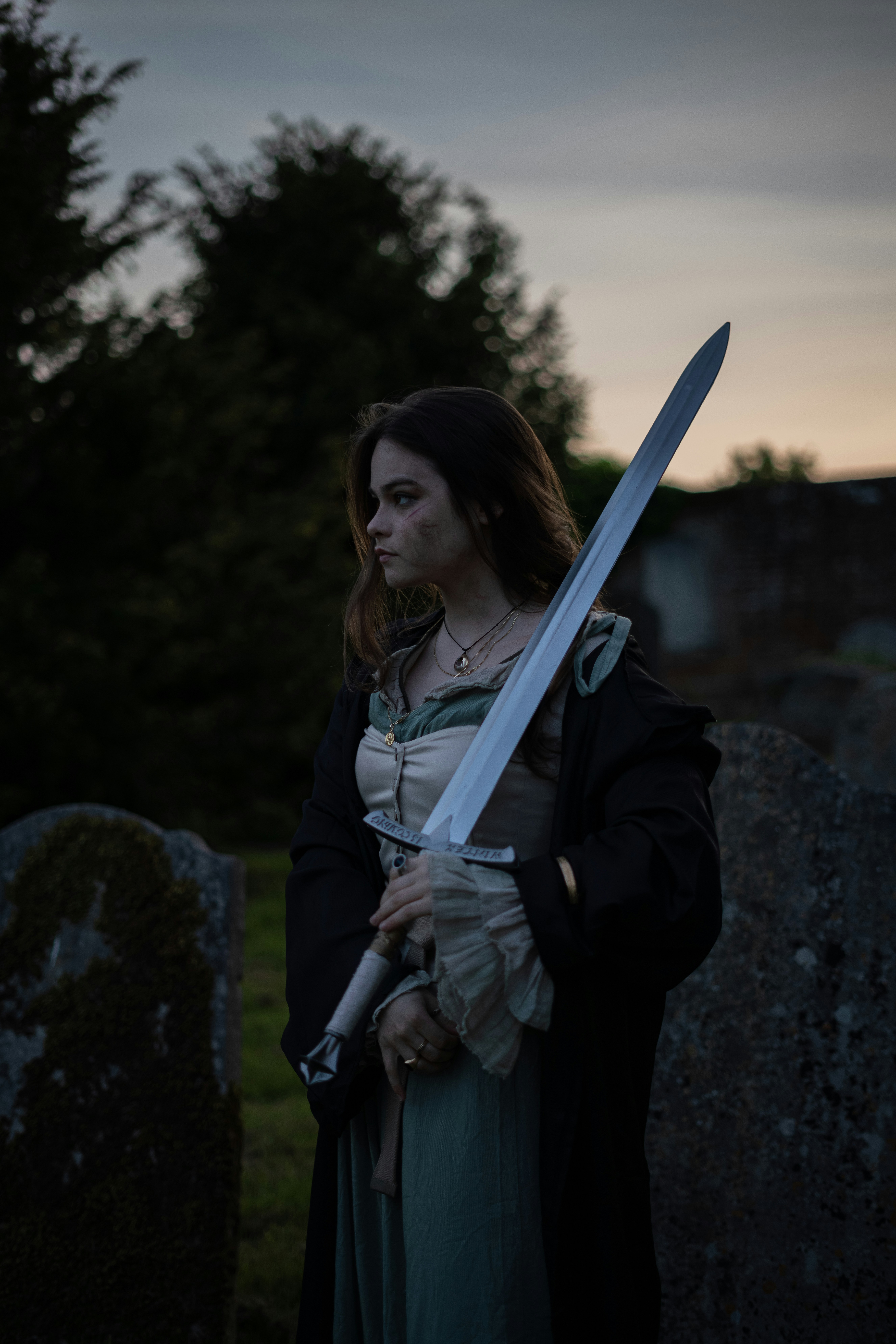 A woman holding a sword in a graveyard photo – Free Sword Image on Unsplash