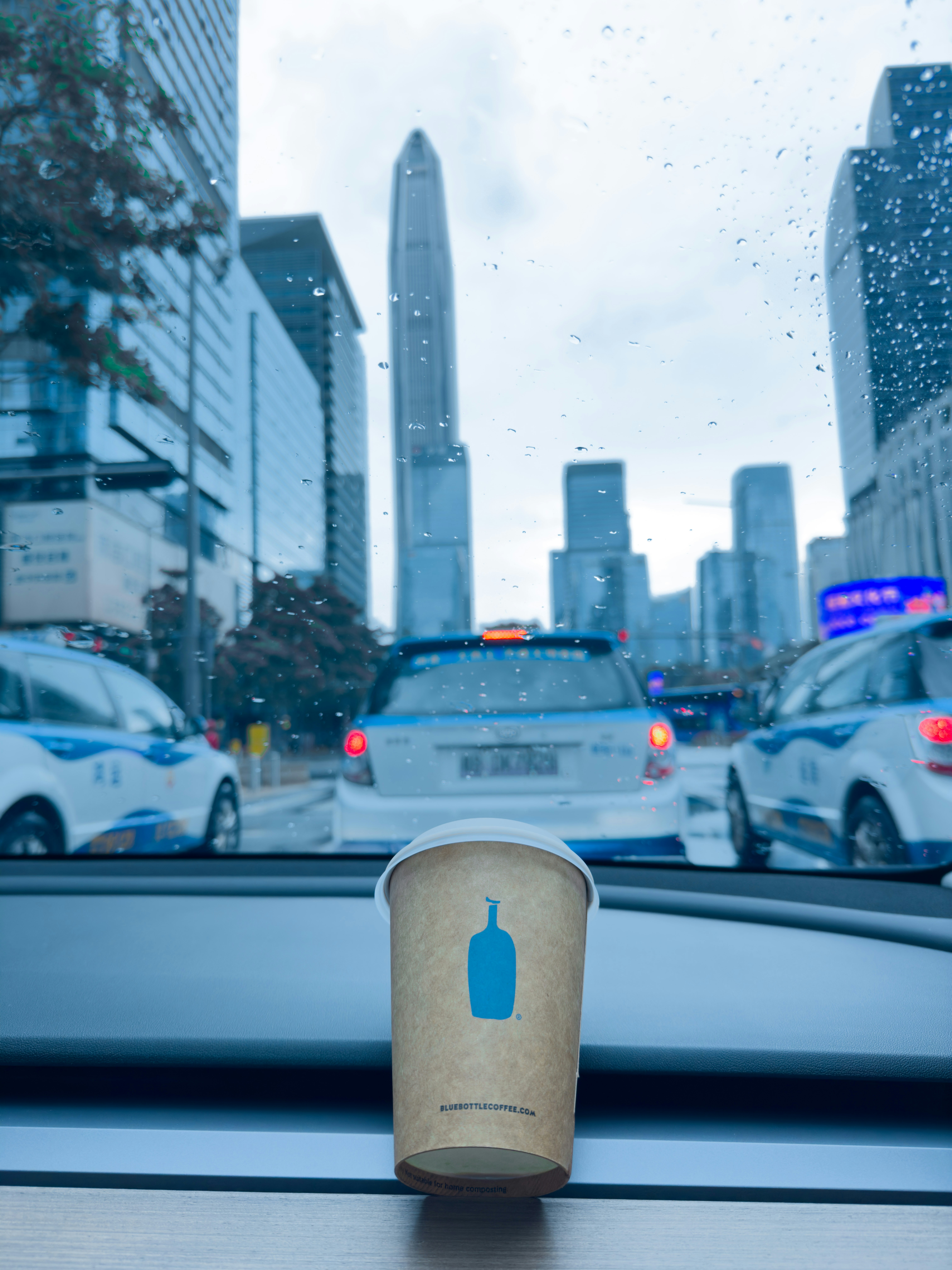 Coffee Cup on a Wet City Drive: Blue Logo, Blue Skyline