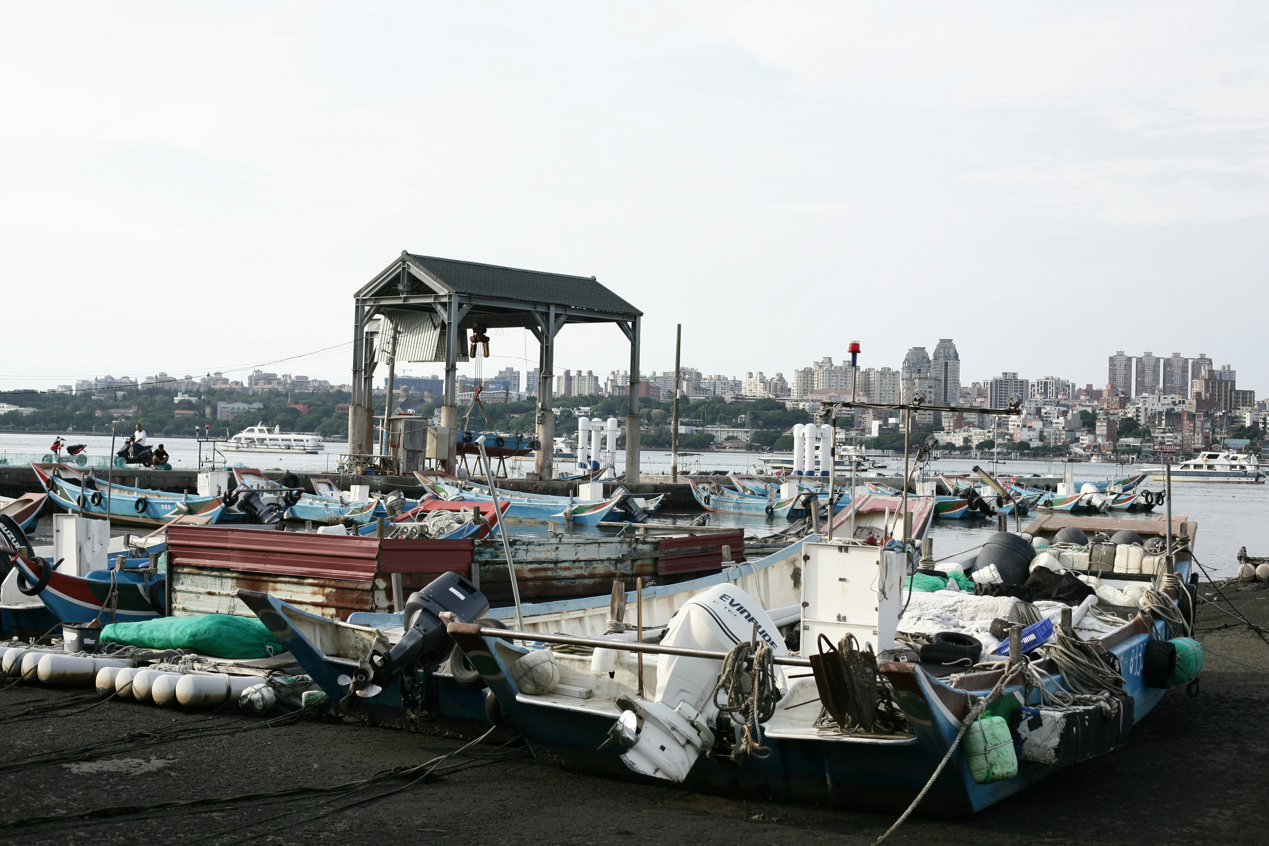 Weathered Shelter Framing a Fleet Against a Distant City Horizon