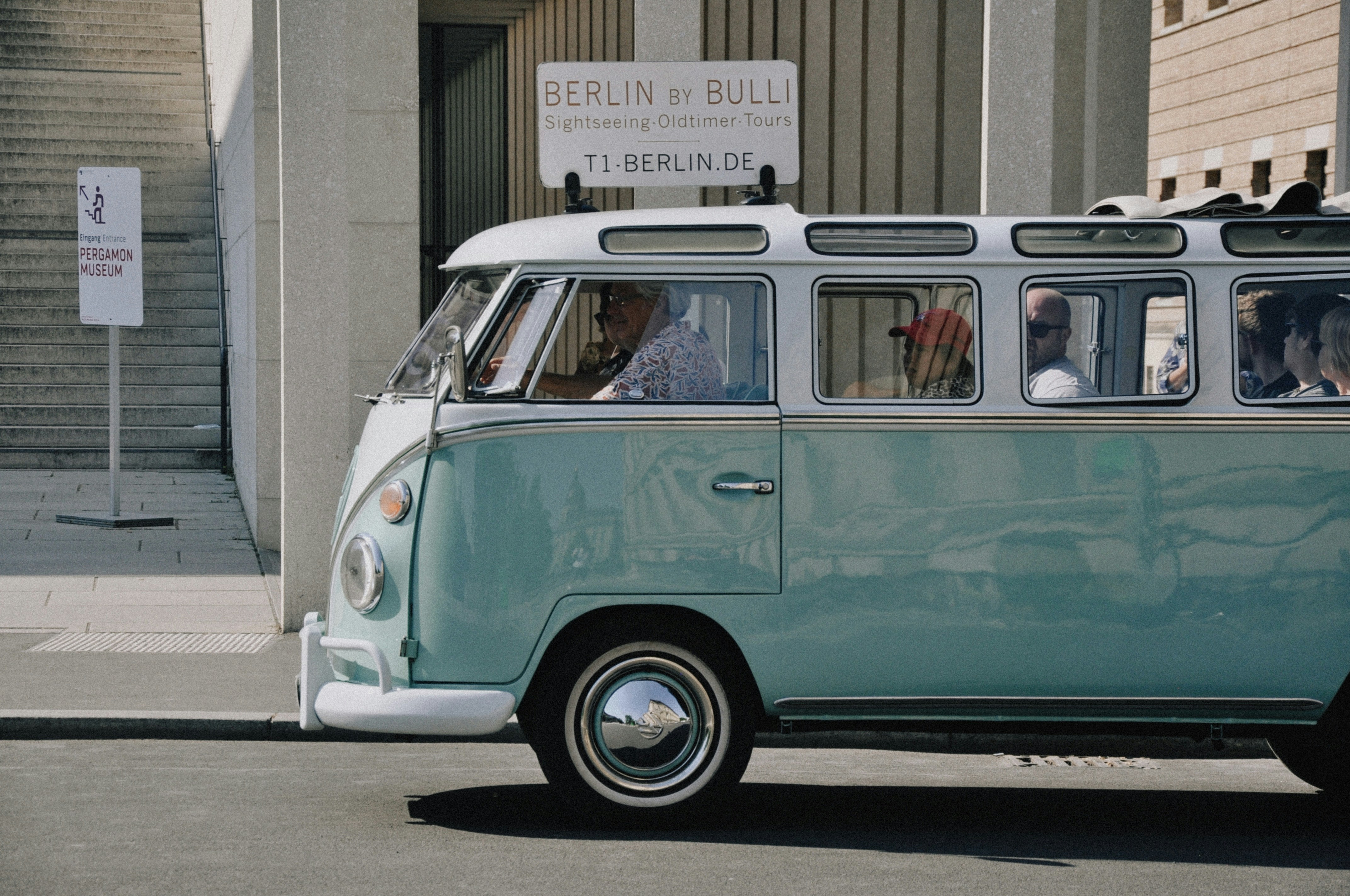 A blue and white bus driving down a street photo – Free Berlin Image on ...