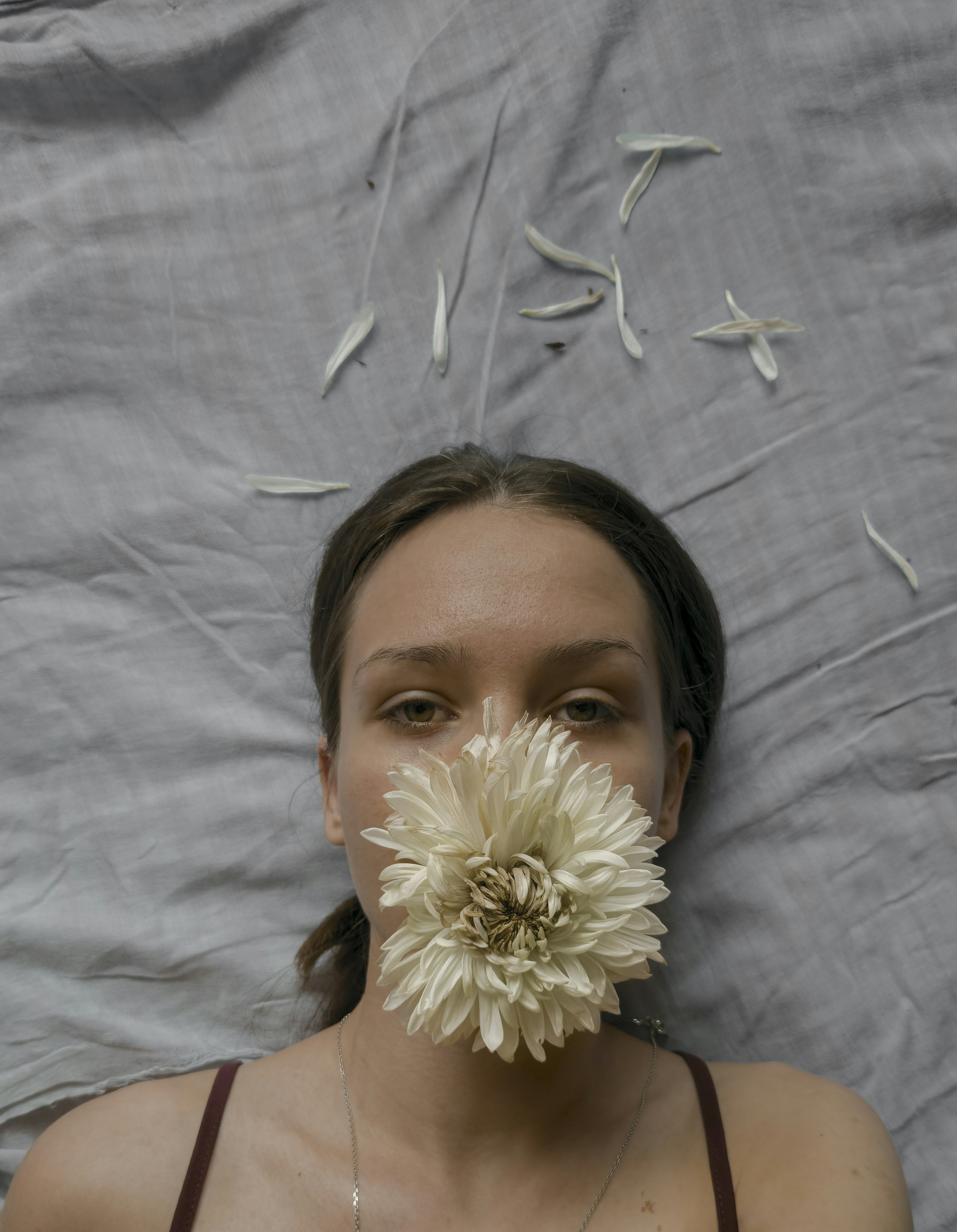 Una mujer acostada en la cama con una flor en la boca foto – Imagen de ...