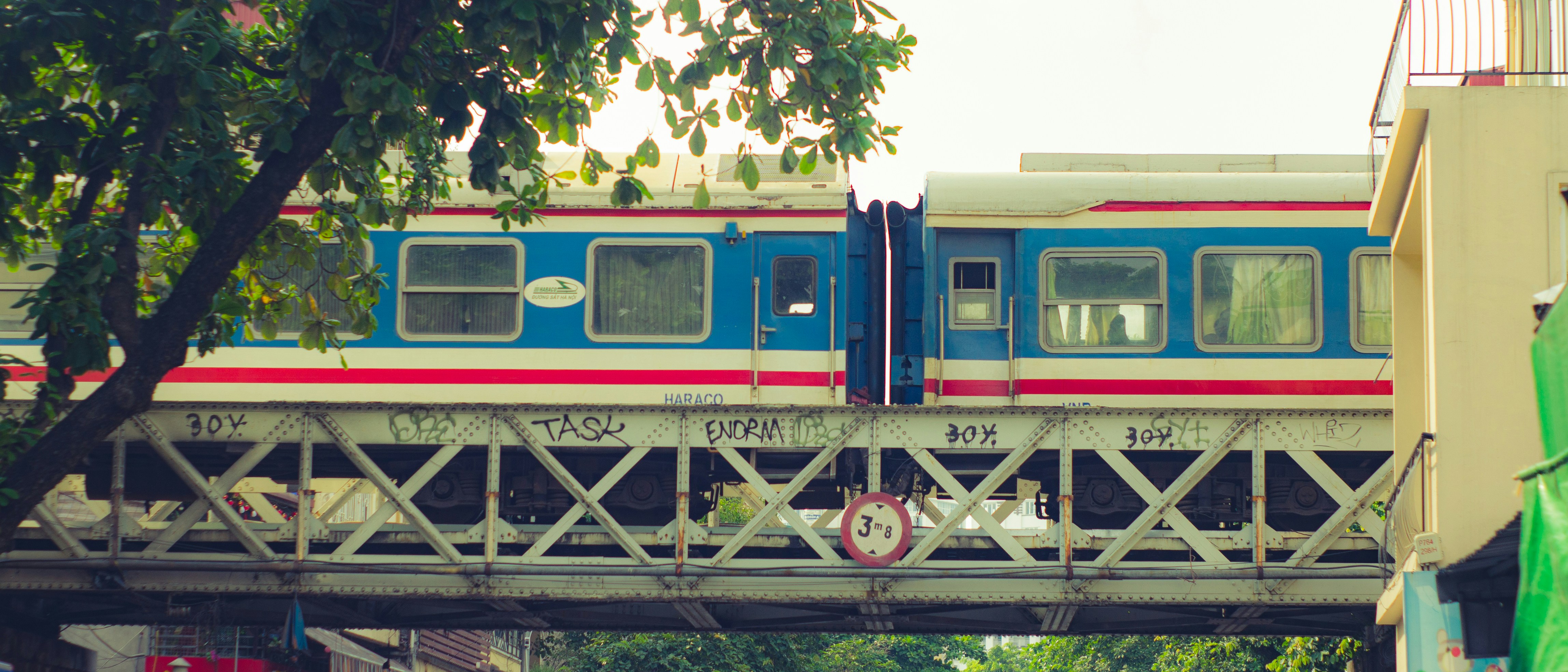 A blue and red train traveling over a bridge photo – Free City Image on ...