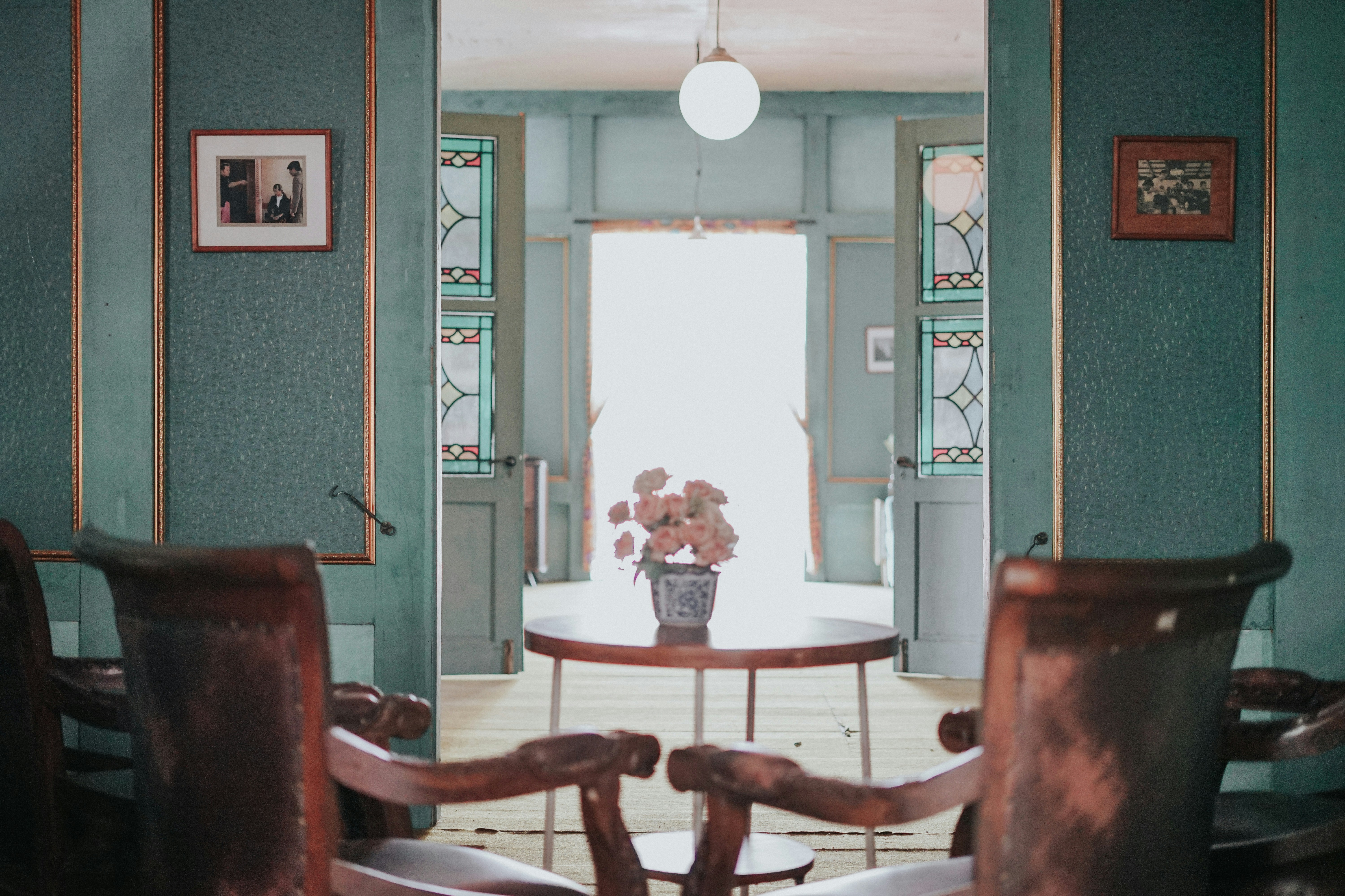 Teal Aerie: Central Vase Framed by Open Doors in Quiet Interior