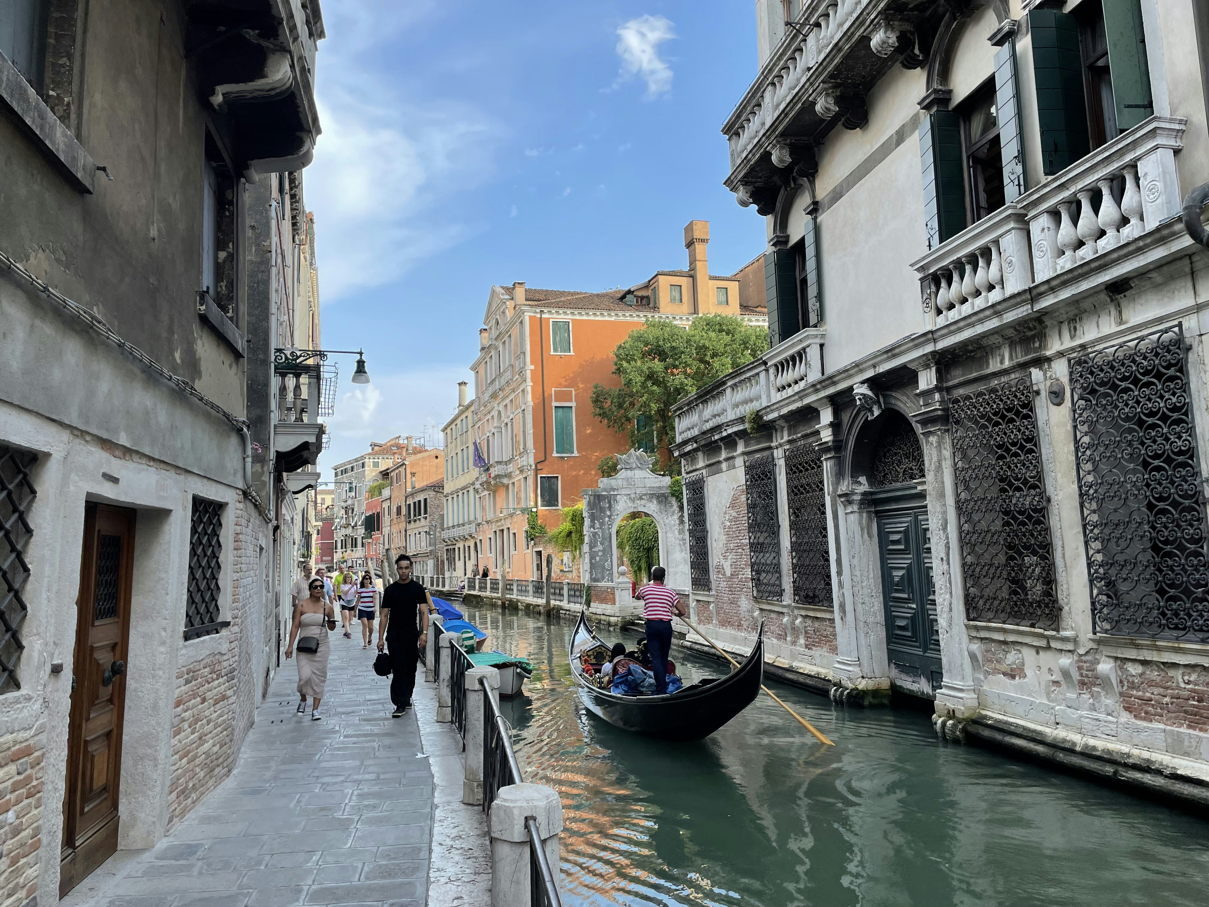 Gondola Drift Beneath Sunlit Facades Along a Venetian Canal