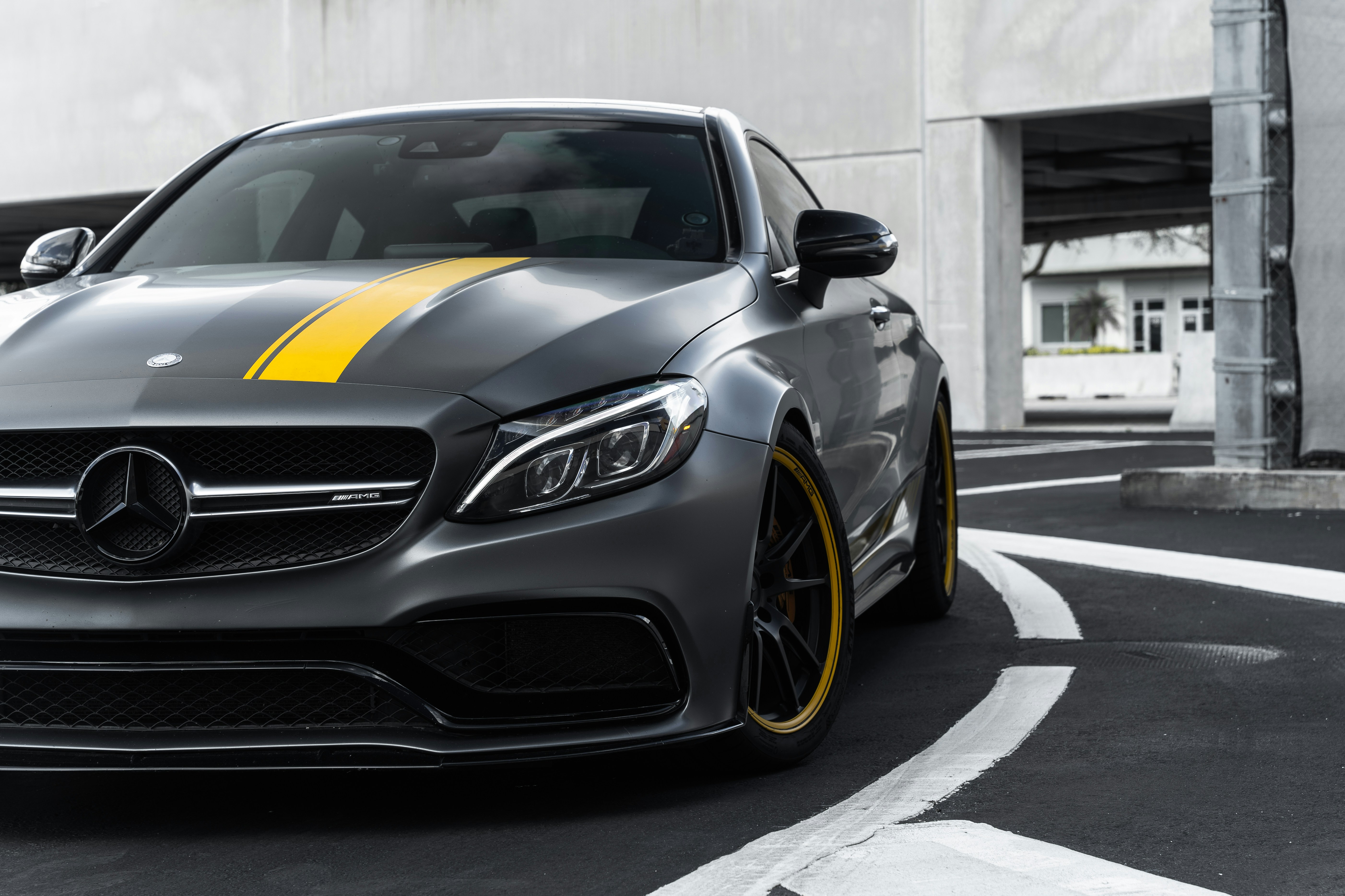 A grey car with a yellow stripe parked in a parking lot photo – Free ...